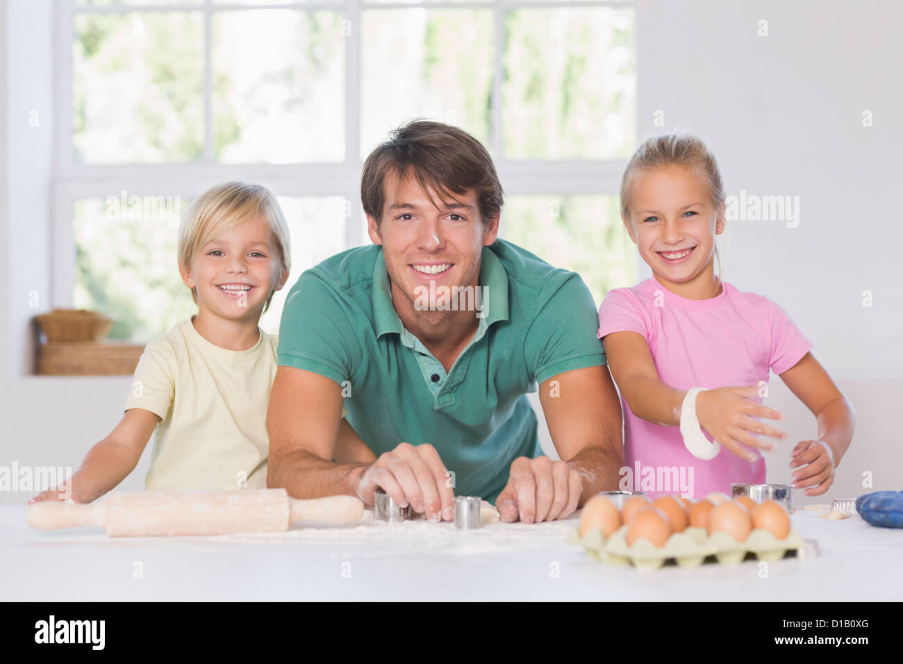 Smiling family with baking tools Stock Photo - Alamy