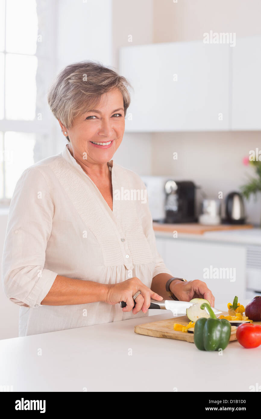 Old woman cutting vegetables on a cutting board with a smile Stock ...