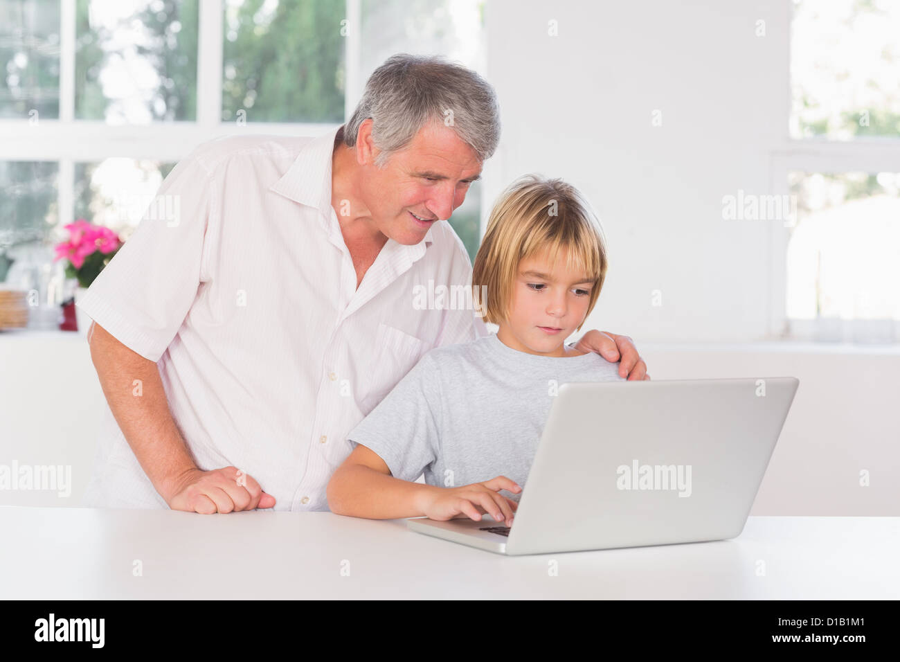 Grandfather and child looking at laptop with smile Stock Photo - Alamy