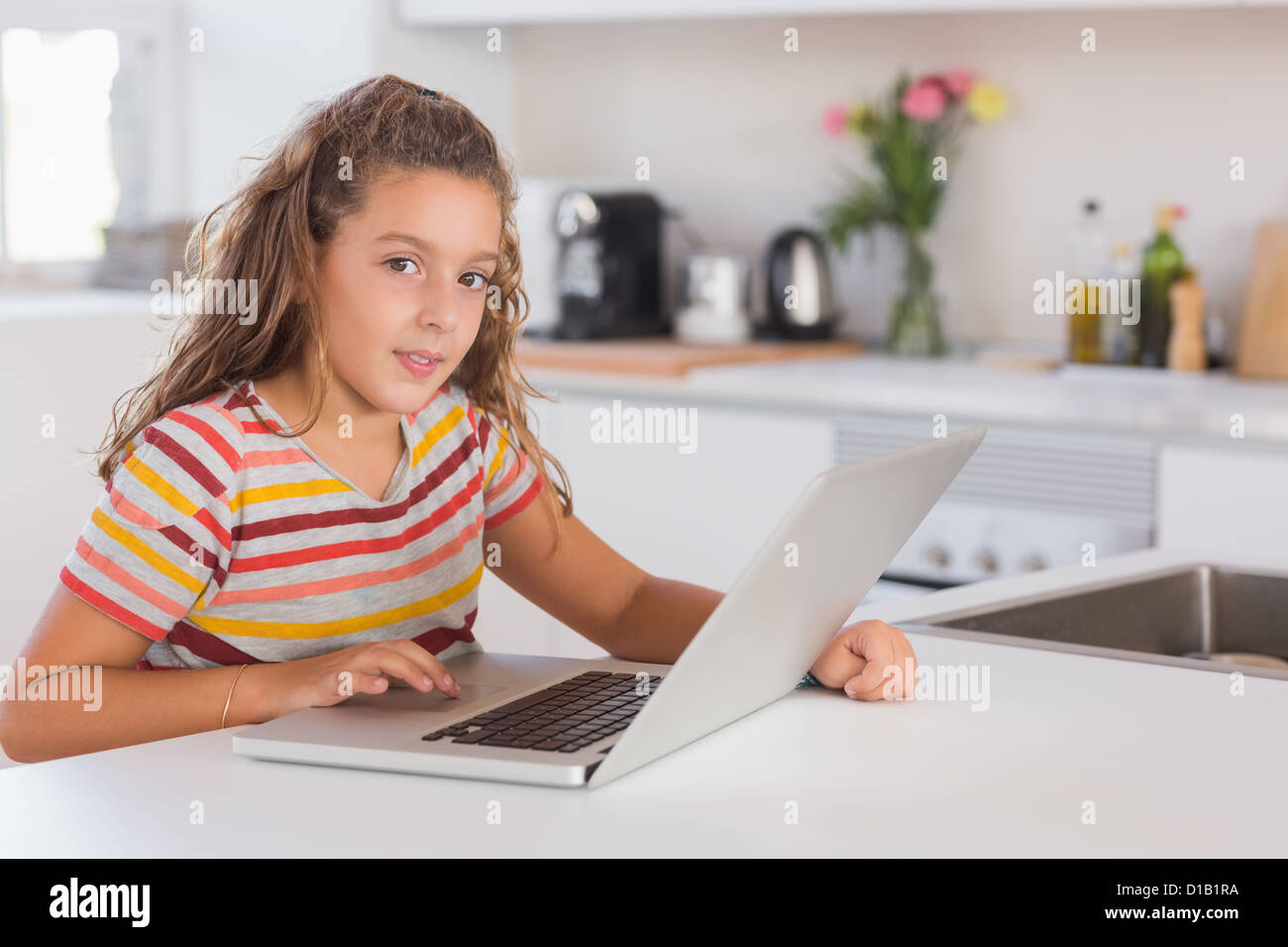 Smiling child looking at the camera with laptop Stock Photo - Alamy