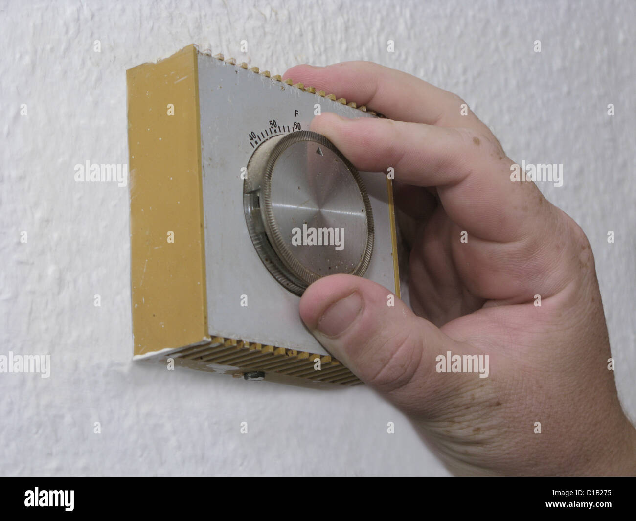 Energy efficiency - man lowering the thermostat on the central heating ...