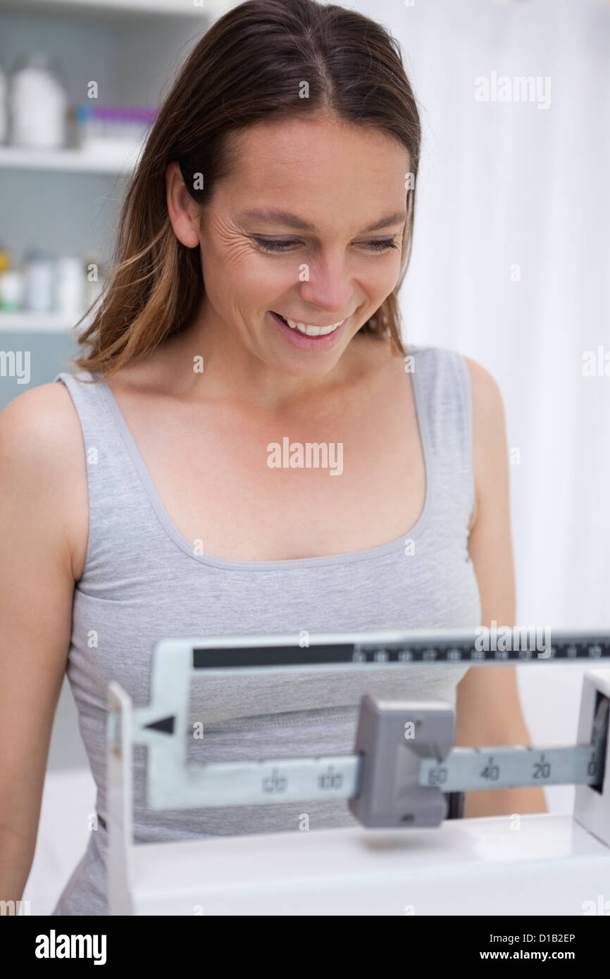 Smiling woman on scale Stock Photo - Alamy