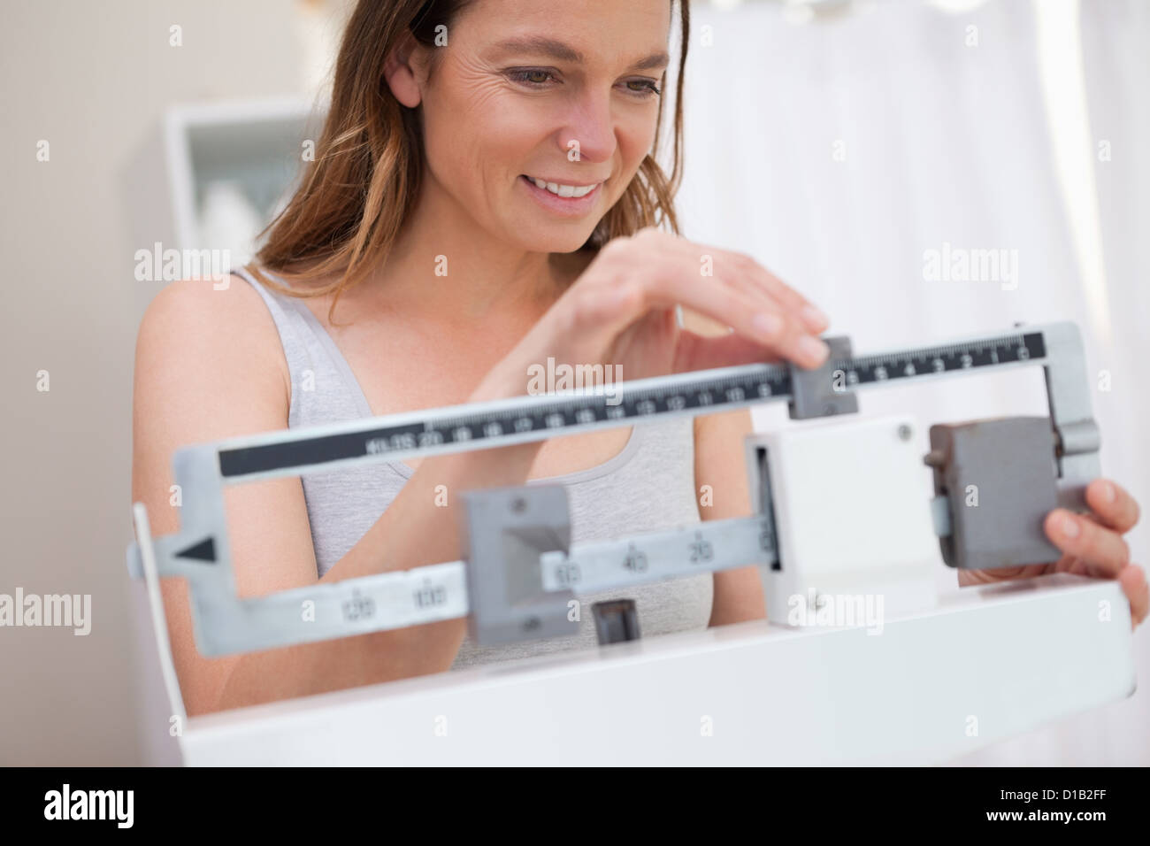 Woman adjusting medical scale Stock Photo - Alamy