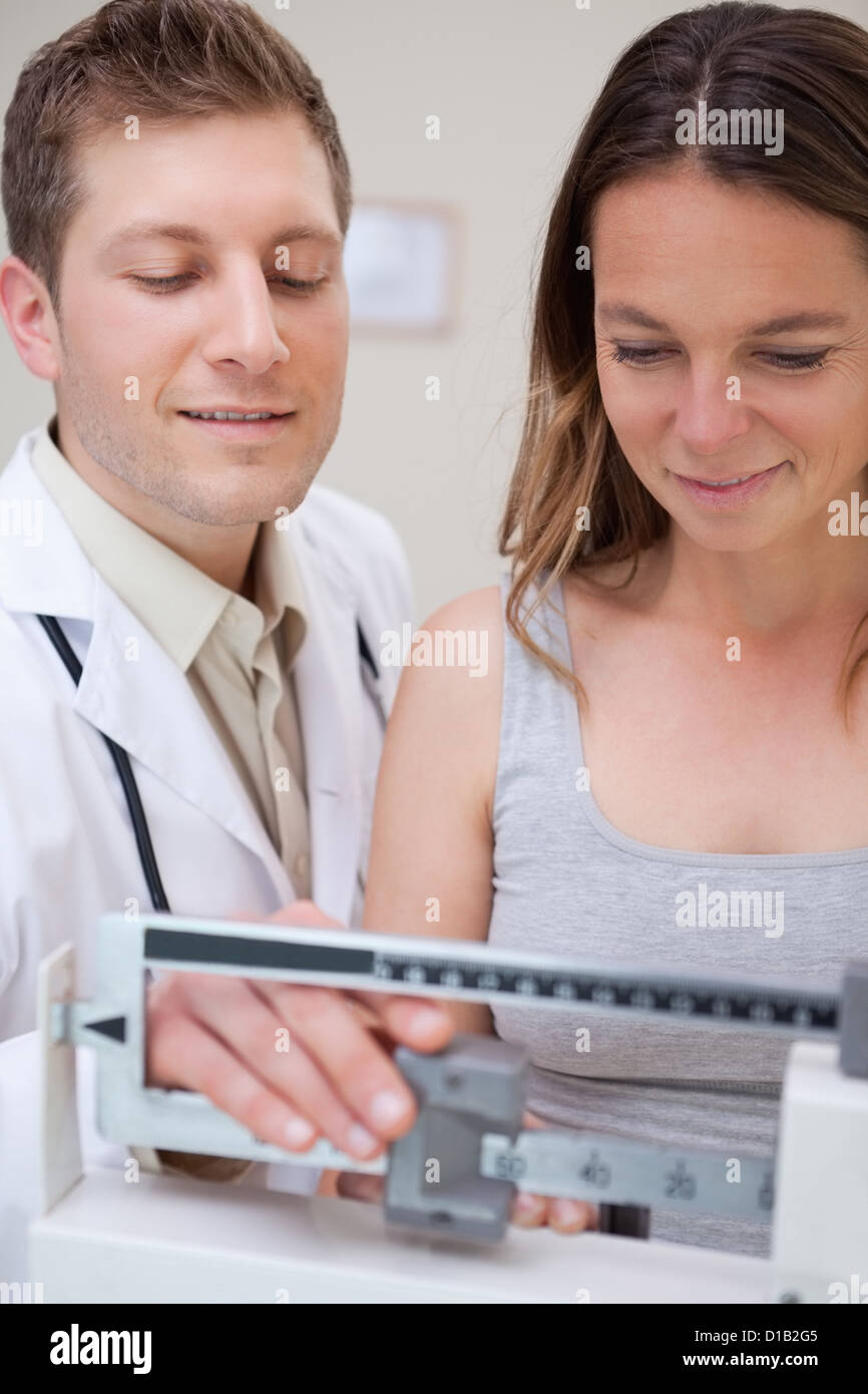 Doctor and patient adjusting scale Stock Photo - Alamy