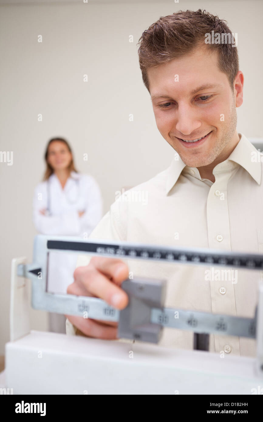 Man adjusting scale while being supervised Stock Photo - Alamy