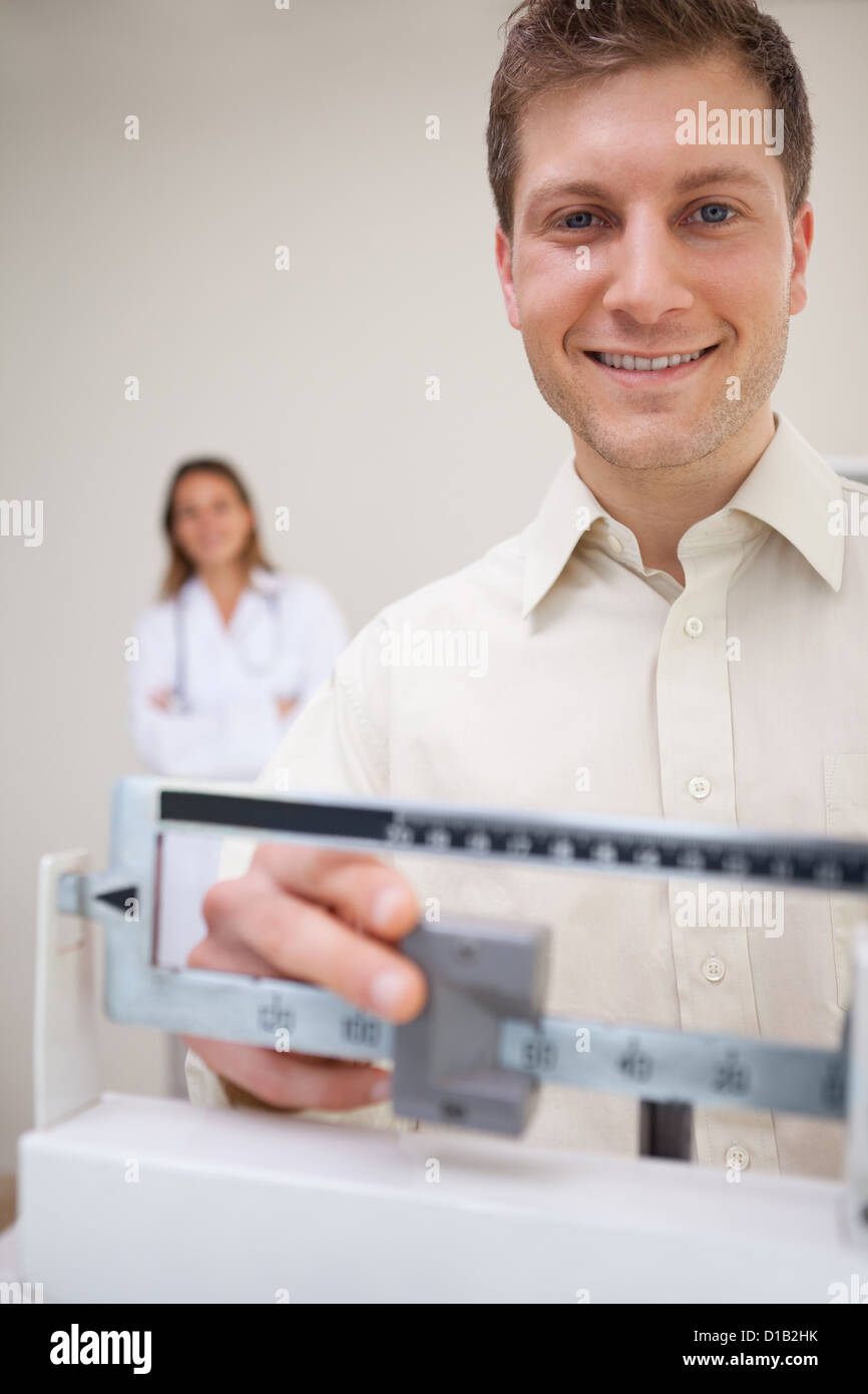 Smiling man adjusting scale Stock Photo - Alamy