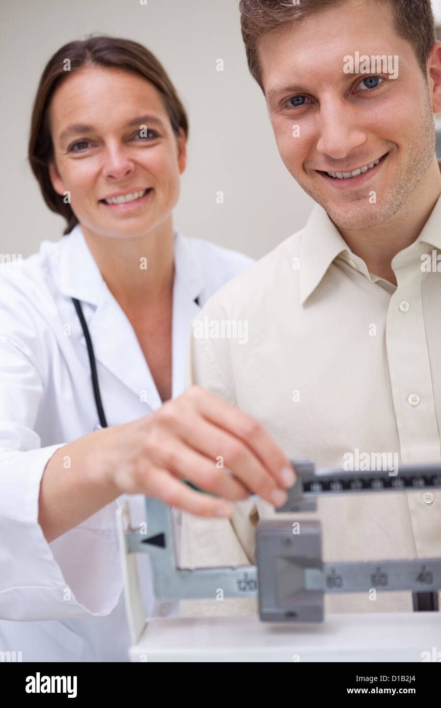 Doctor measuring patients weight Stock Photo - Alamy