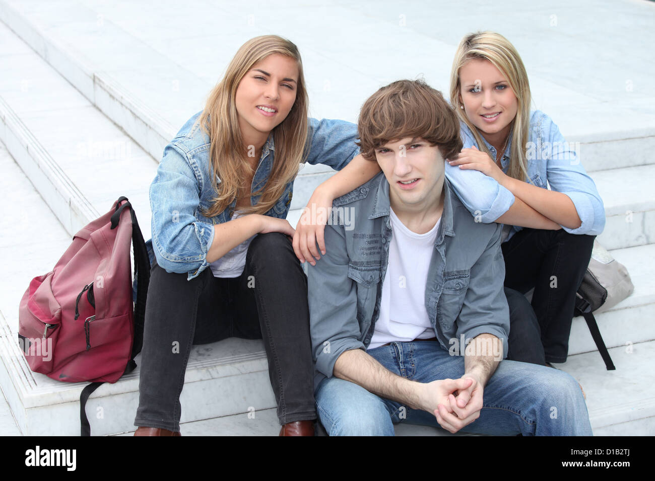 Three teenage friends sat on steps Stock Photo - Alamy