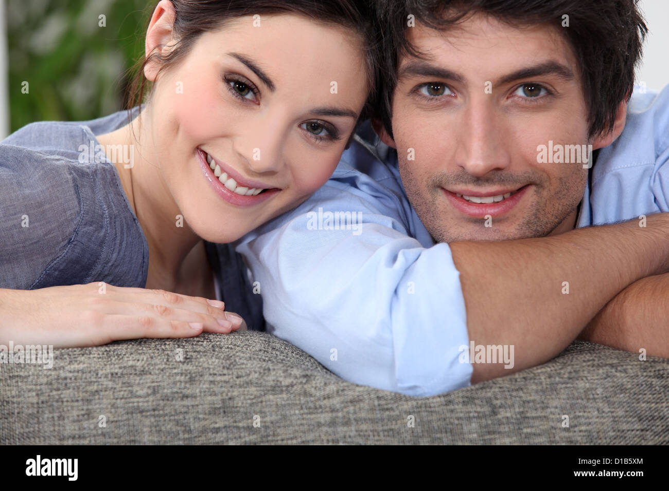 Couple embracing on couch Stock Photo - Alamy