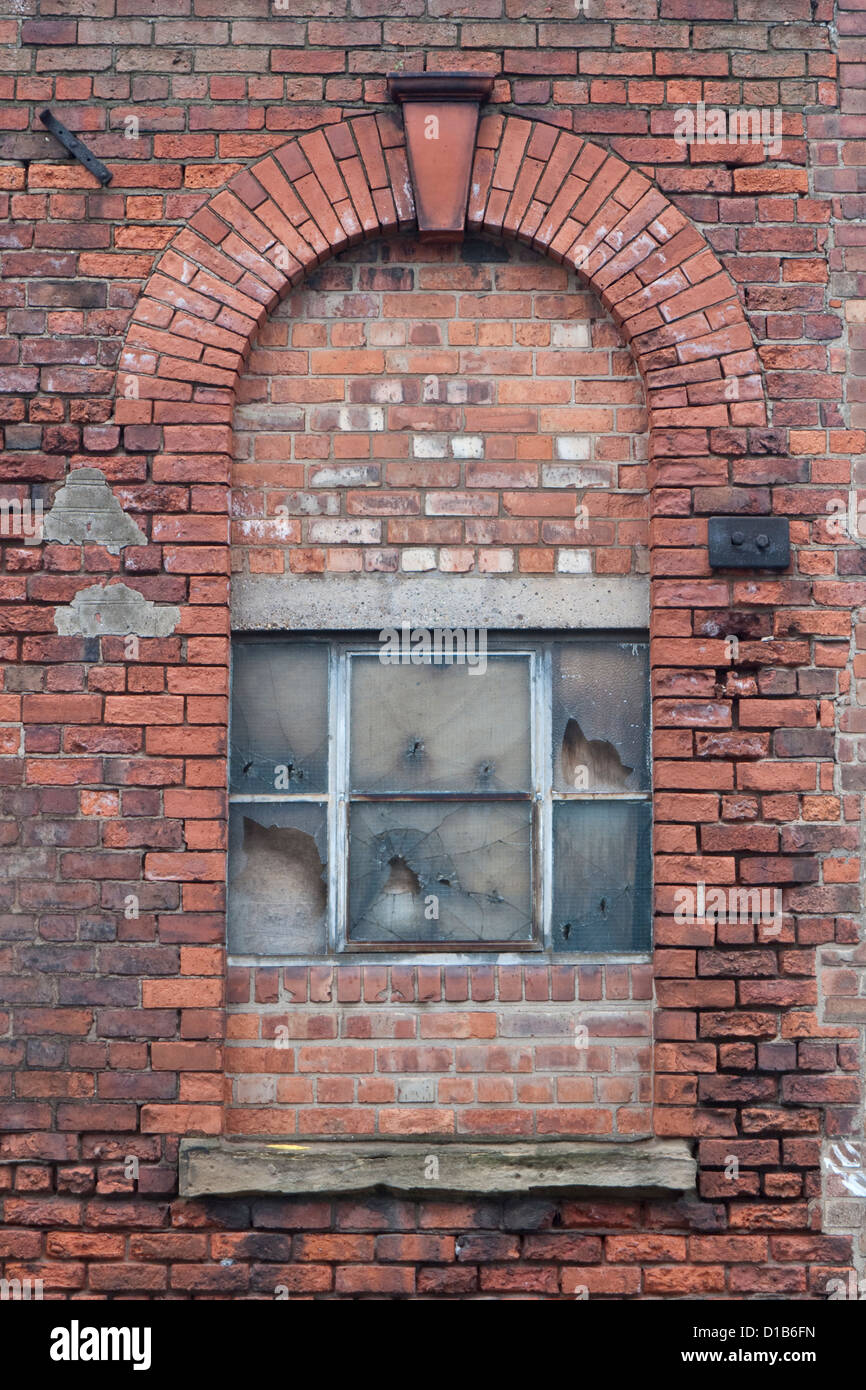 Broken window in a brick wall of an abandoned derelict factory in ...