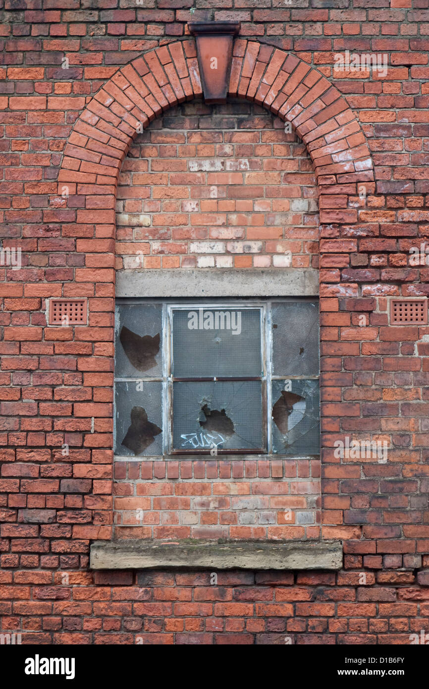 Broken window in a brick wall of an abandoned derelict factory in ...
