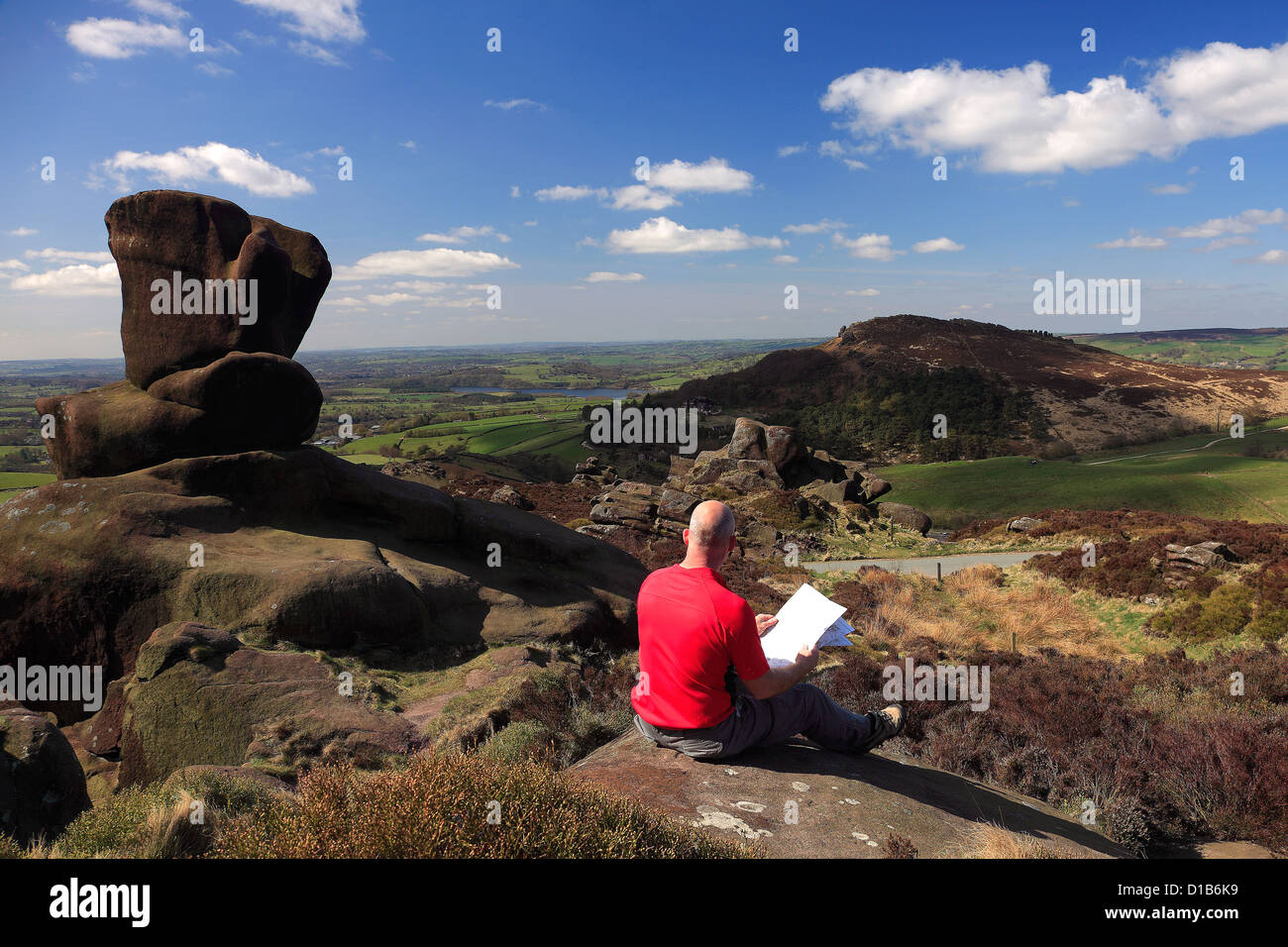 Adult Male walker reading a map by the Sandstone rock formations of the ...
