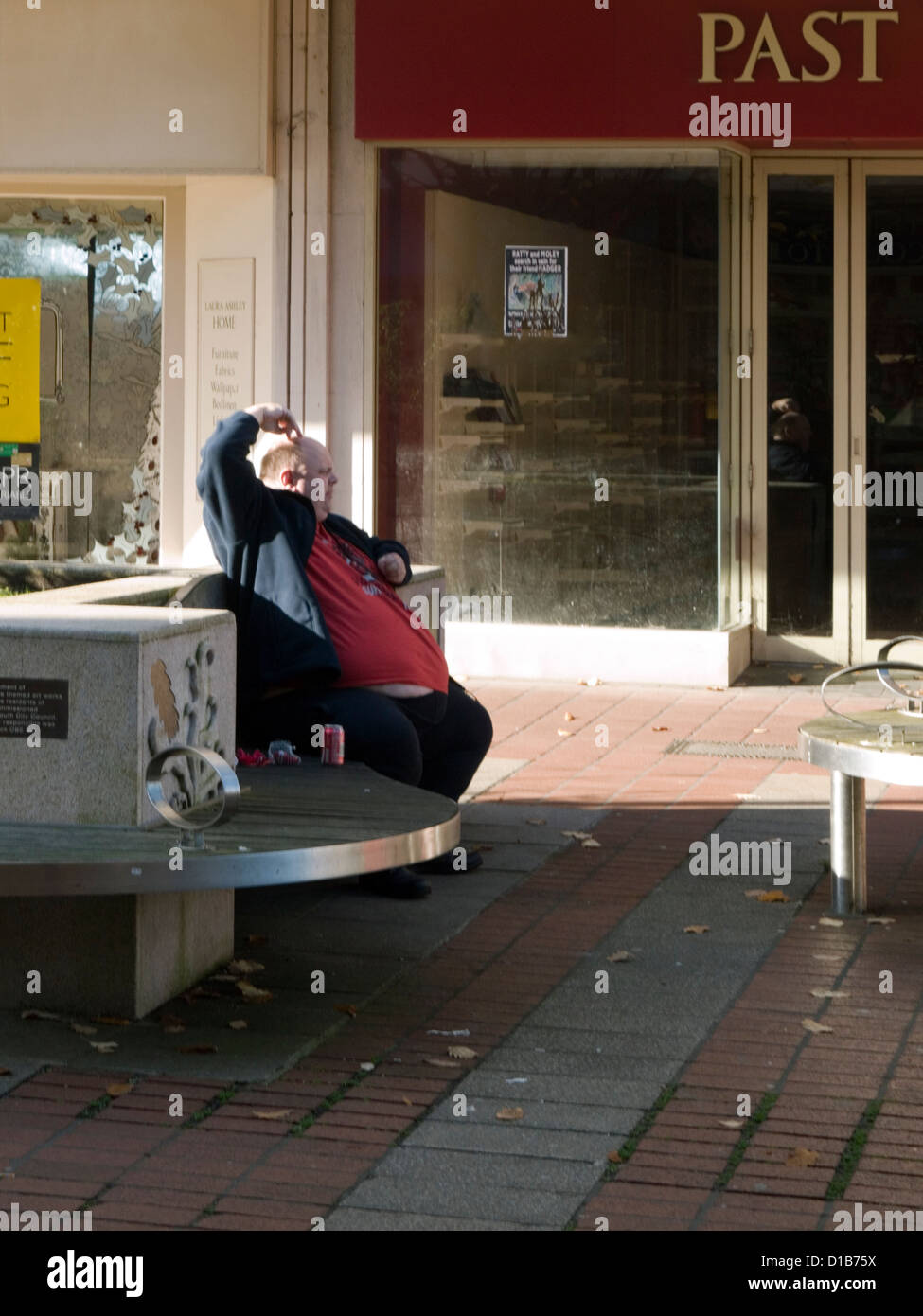very obese man sitting in the sun with snacks beside him Stock Photo ...