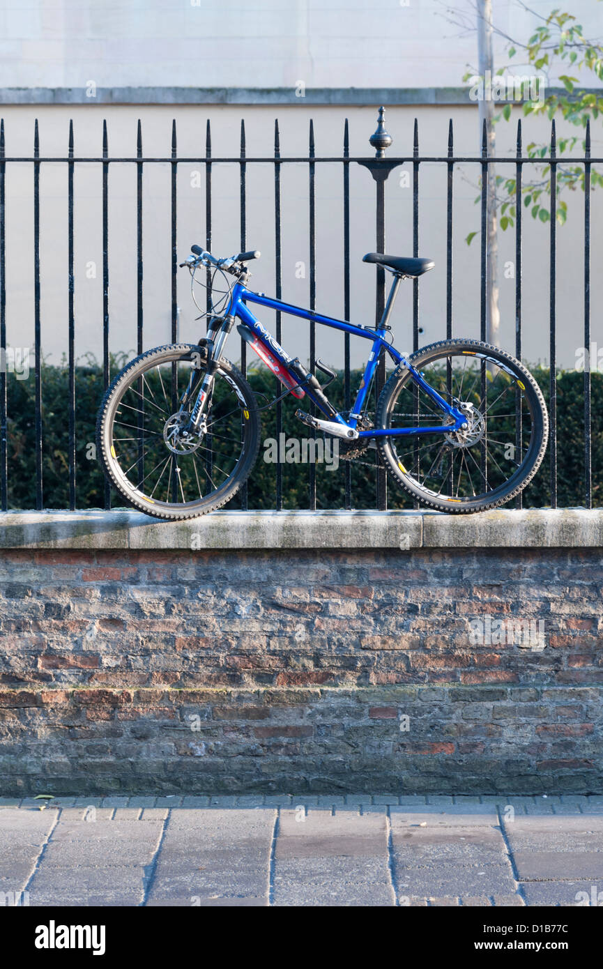 A cycle chained to railings up on a wall in Cambridge UK Stock Photo ...