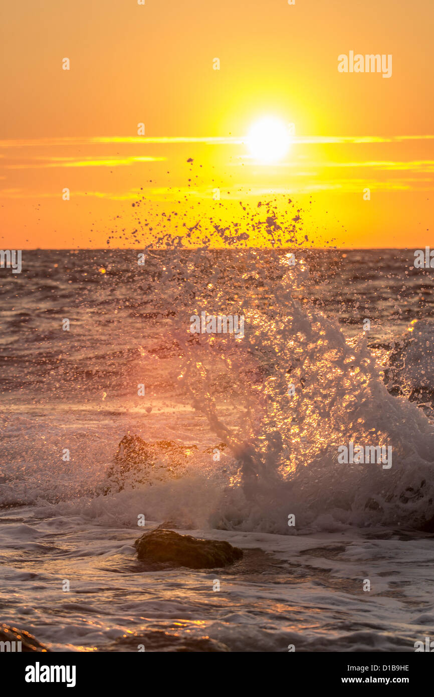 Bright sunset under the sea with waves splashes Stock Photo - Alamy