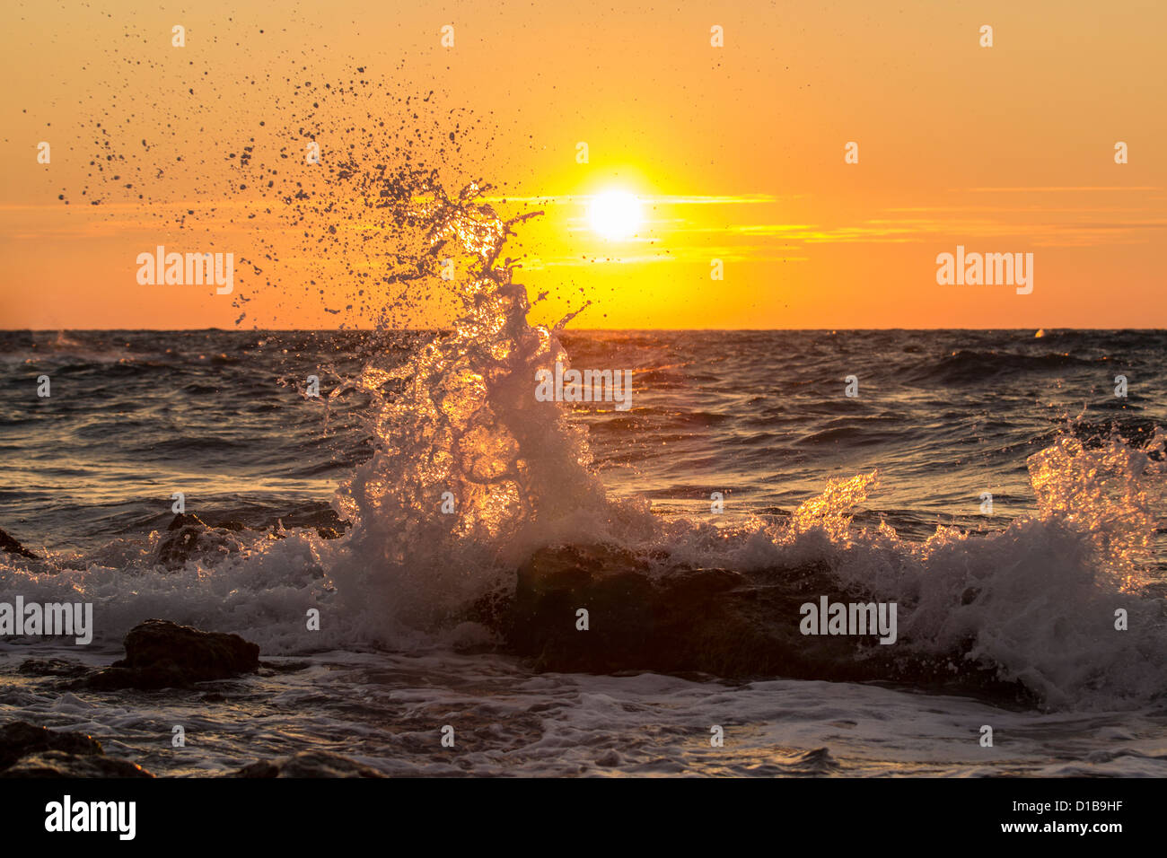 Bright sunset under the sea with waves splashes Stock Photo - Alamy