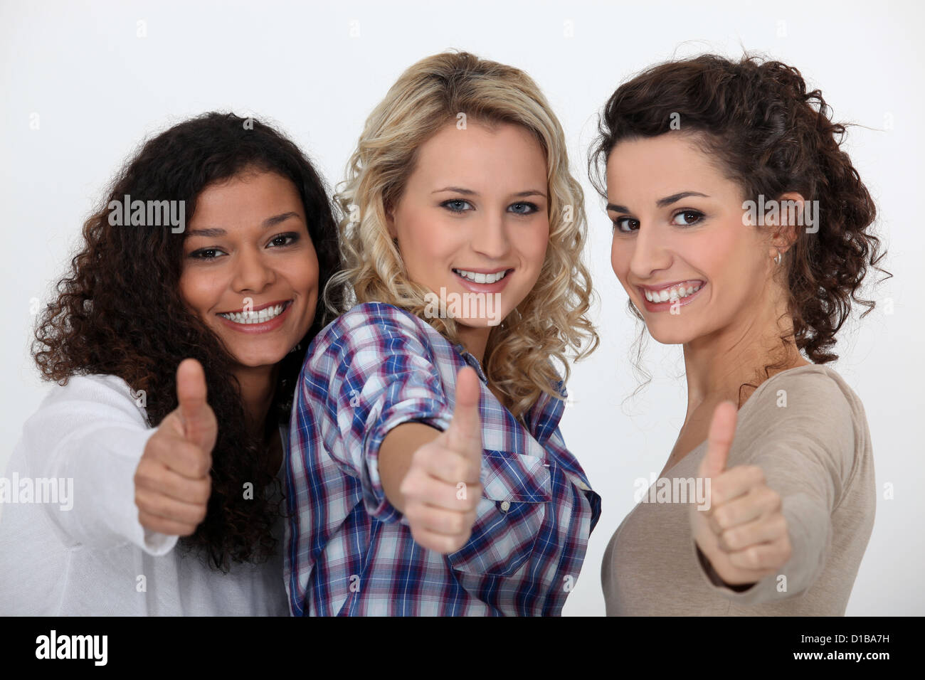 Three happy girls with thumbs up Stock Photo - Alamy