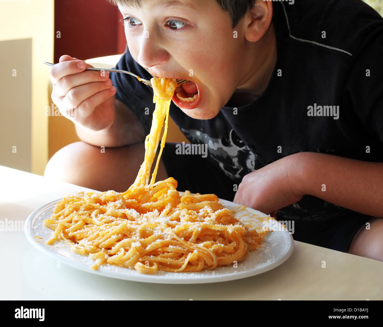 Funny boy eating spaghetti Stock Photo - Alamy
