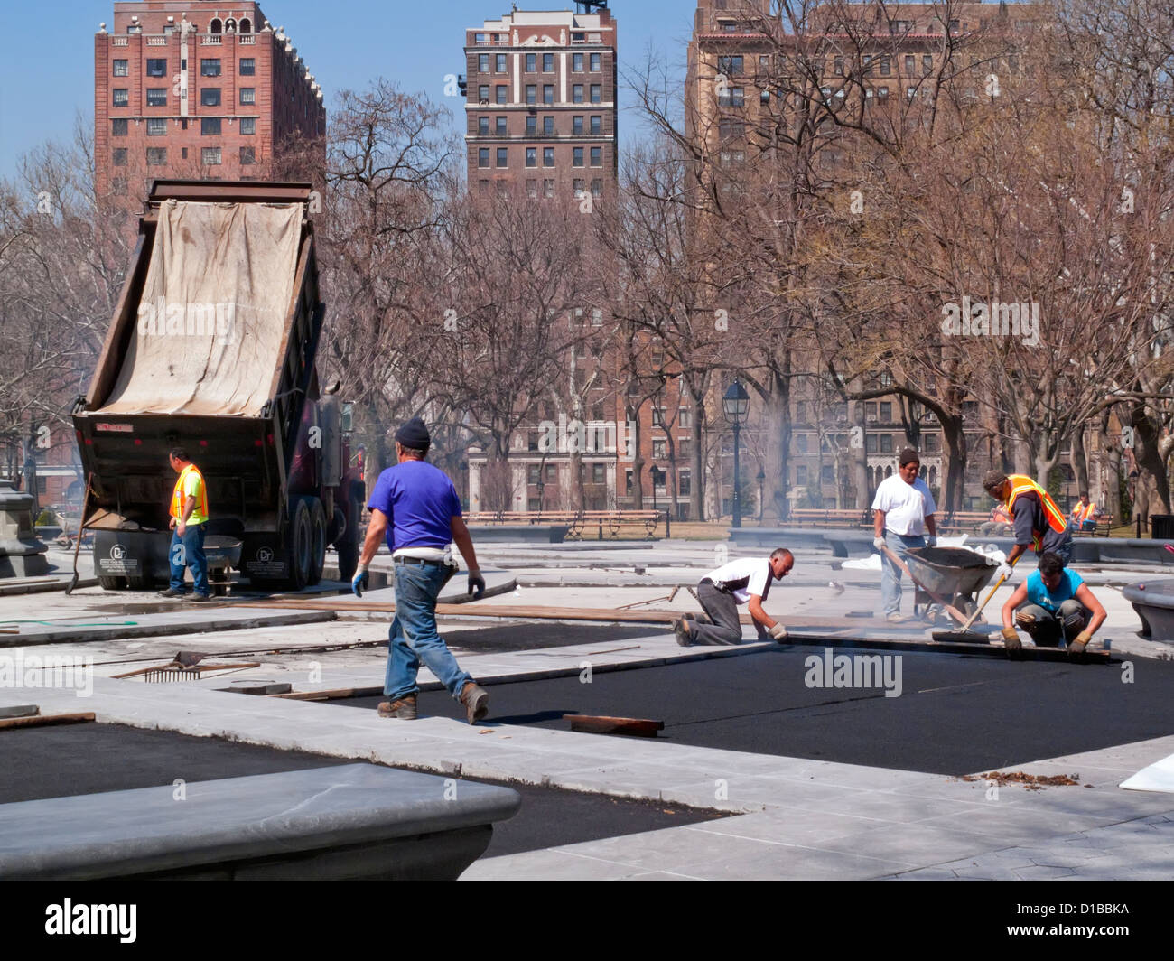 Construction workers lay down stone tiles for the circle in Washington ...