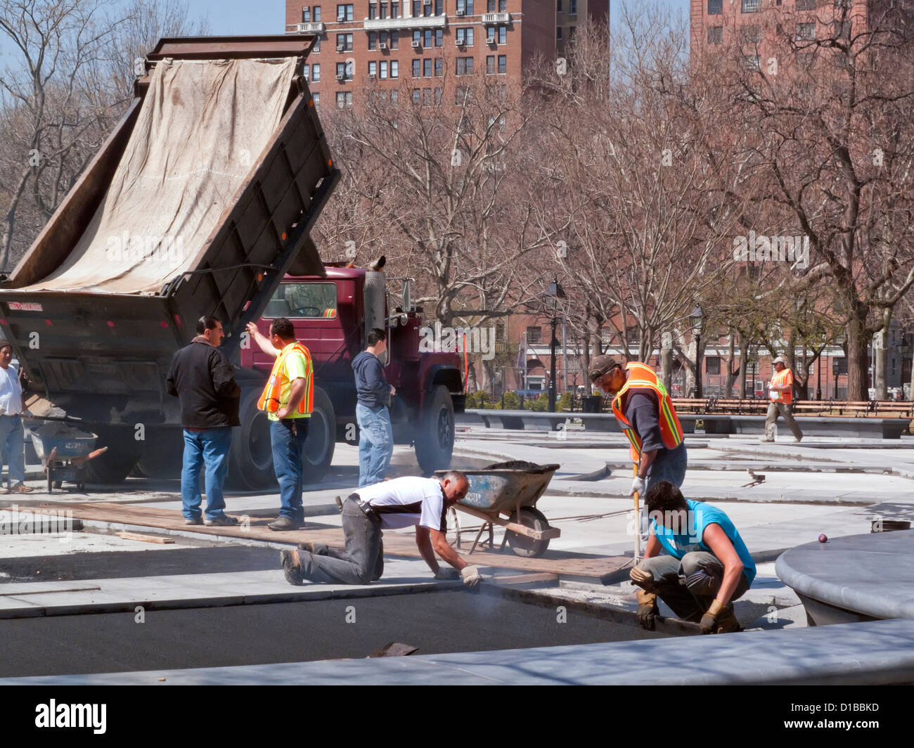Construction workers lay down stone tiles for the circle in Washington ...