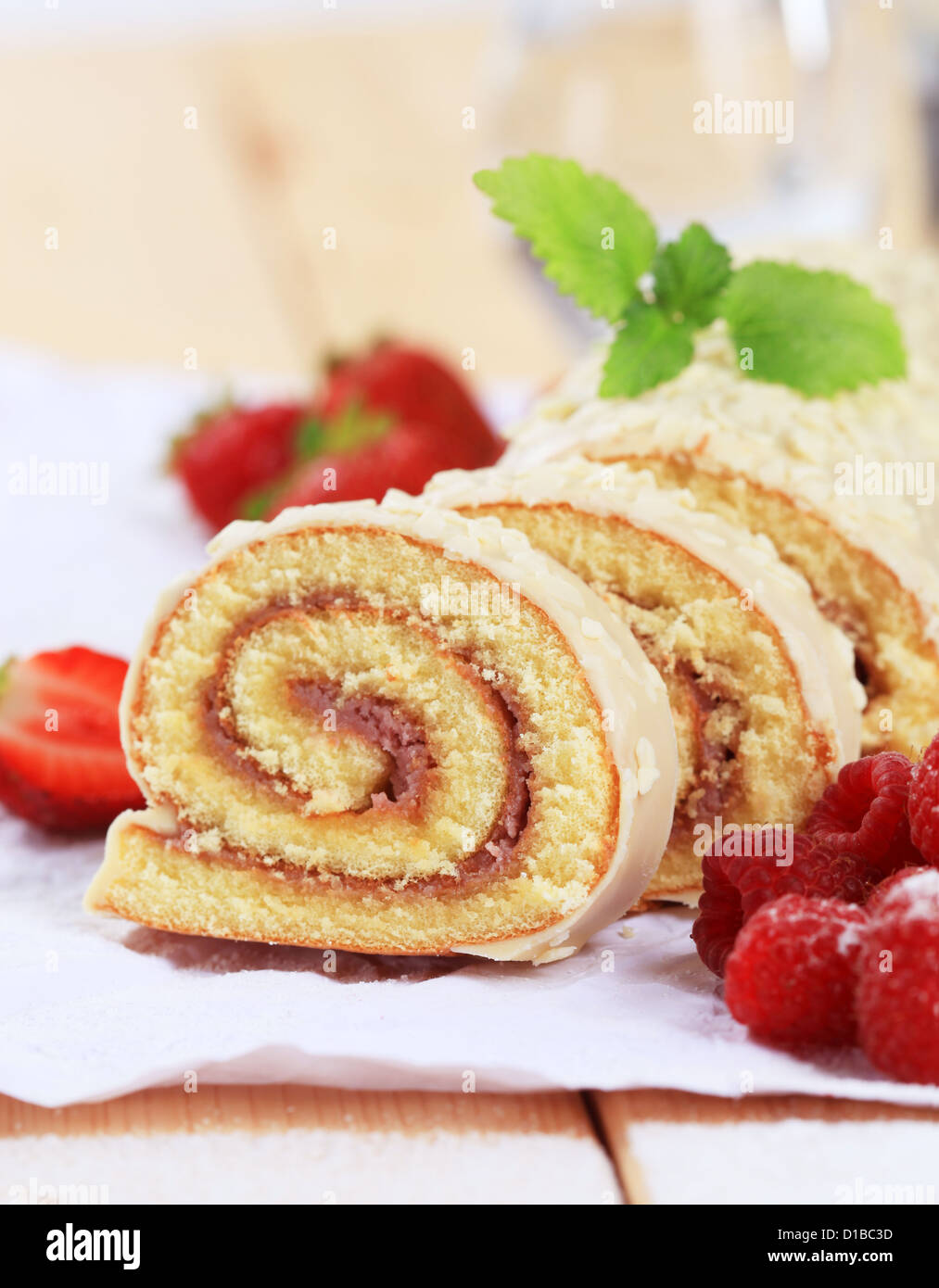 Swiss roll glazed with white chocolate icing Stock Photo - Alamy