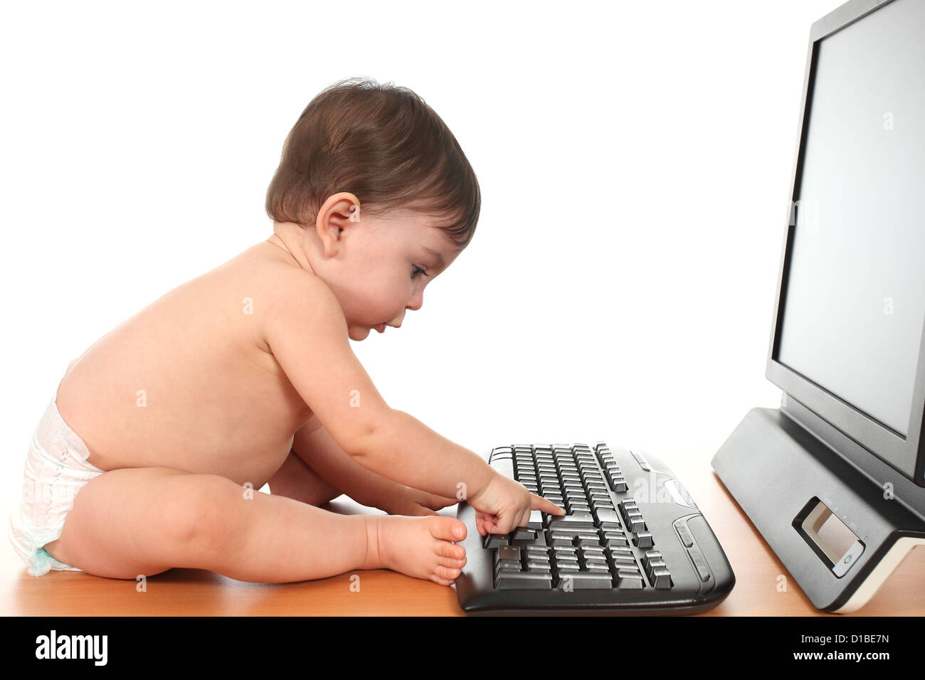 Baby typing enter on a computer keyboard in a white isolated background ...