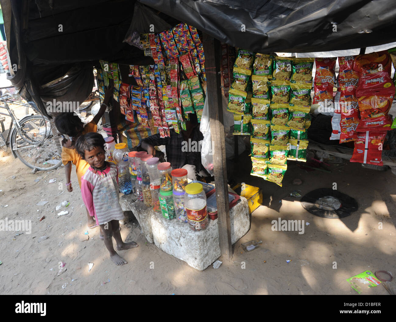 Children are pictured in front of a market stall in a slum in Jaipur ...