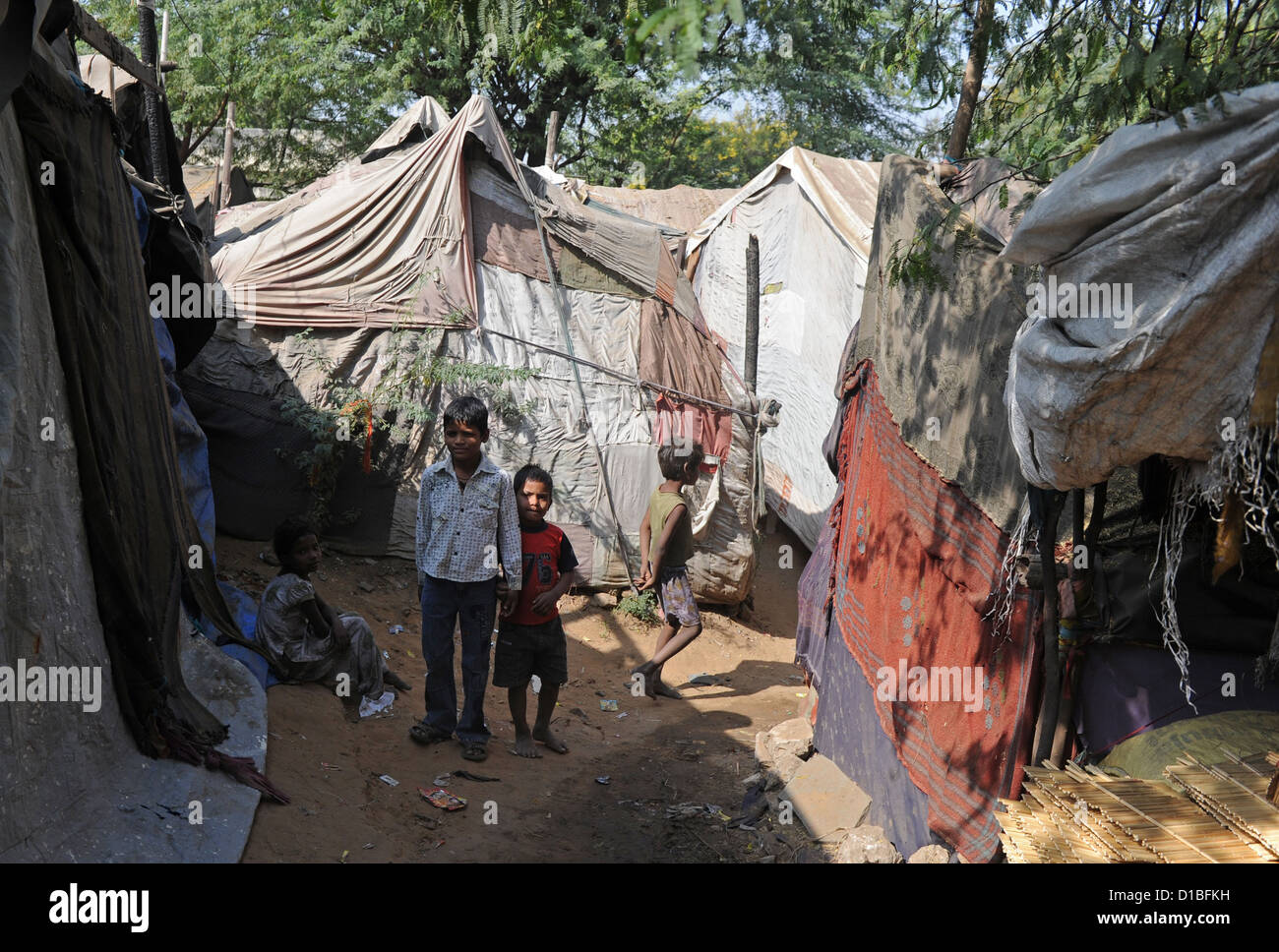 Children walk past huts in a slum in Jaipur, India, 09 November 2012 ...