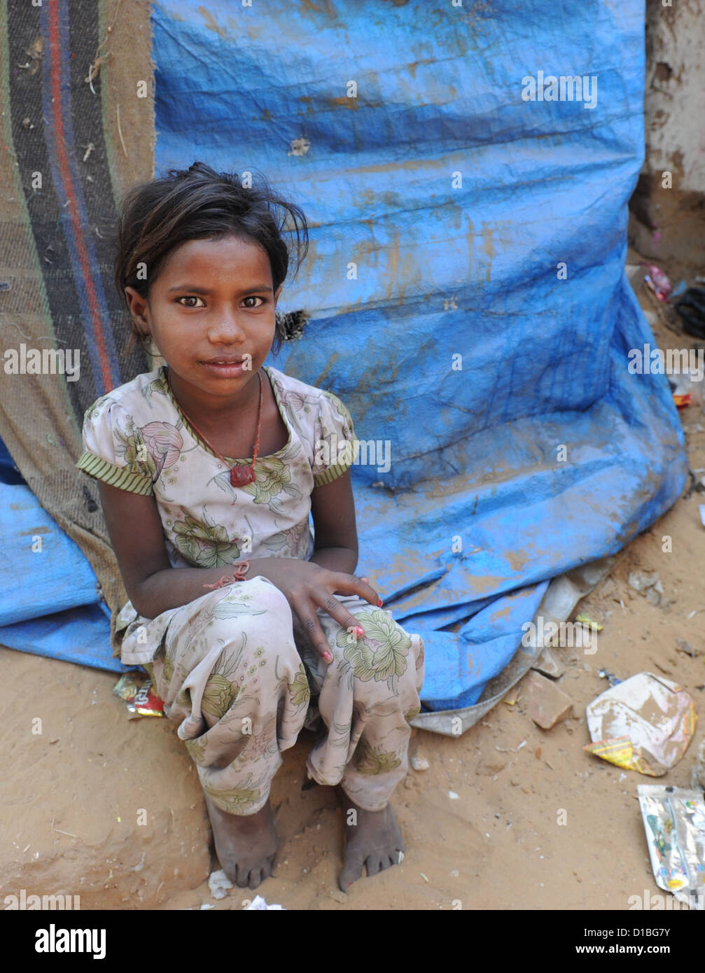 Naika sits in front of the hut of her family in a slum in Jaipur, India ...