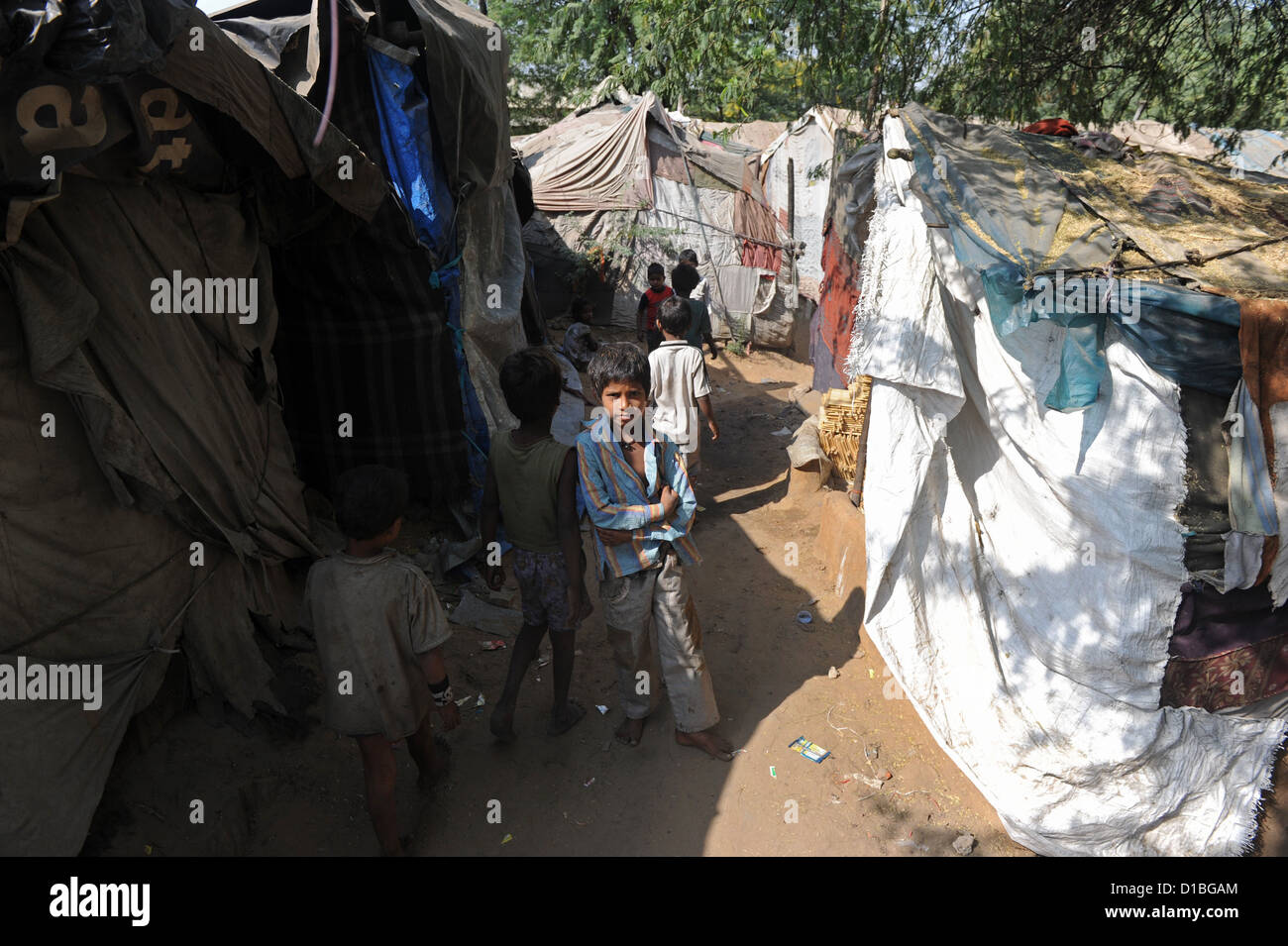 Children walk past huts in a slum in Jaipur, India, 09 November 2012 ...