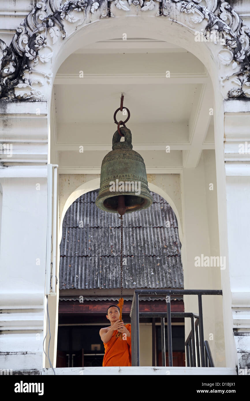 Buddhist monk ringing bell at sunset at the Wat Chedi Luang temple ...