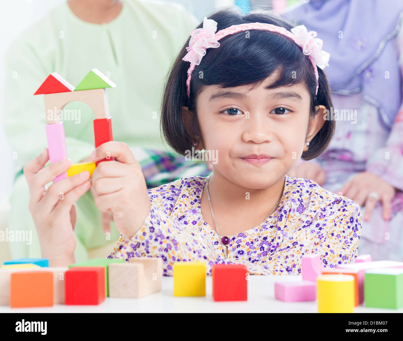 Muslim child building wooden house. Southeast Asian girl playing ...