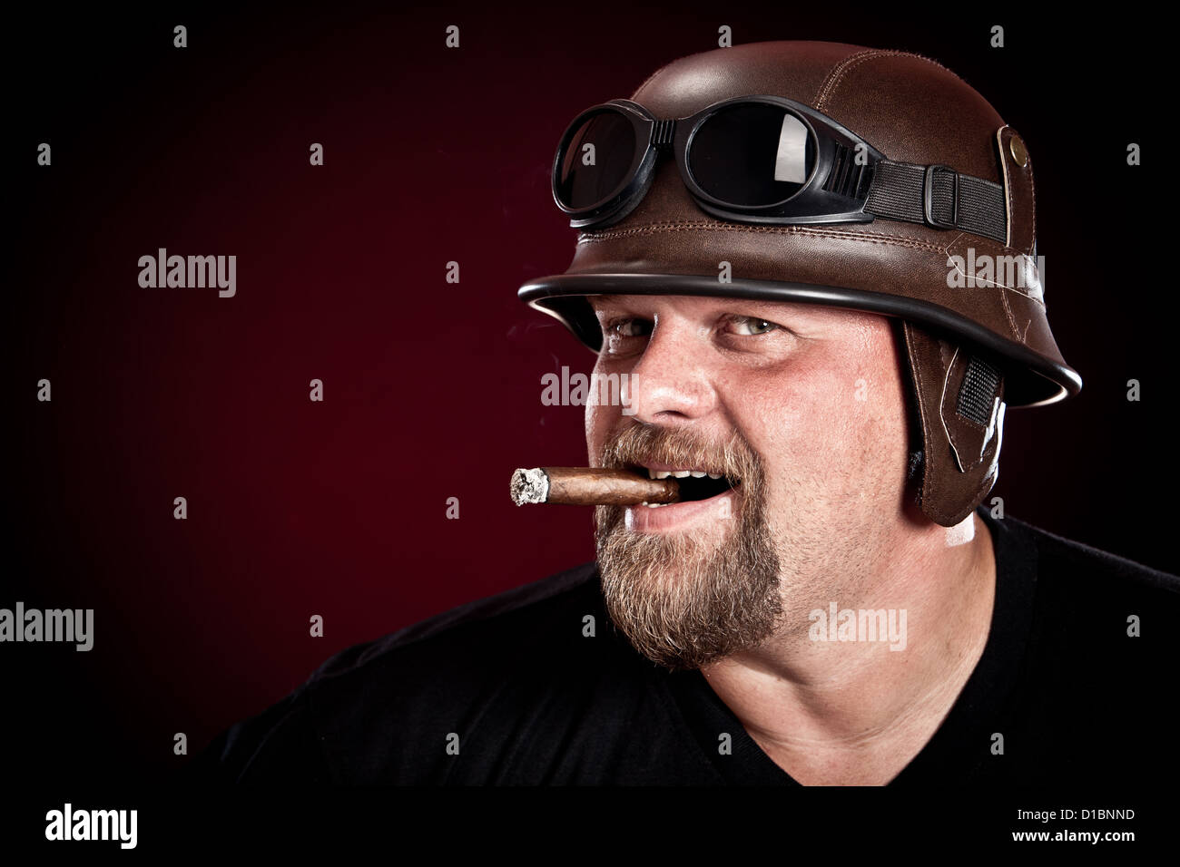 biker in a helmet smokes a cigar on a dark background Stock Photo - Alamy