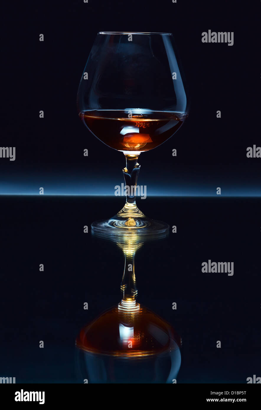 snifter with brandy on a dark background Stock Photo - Alamy