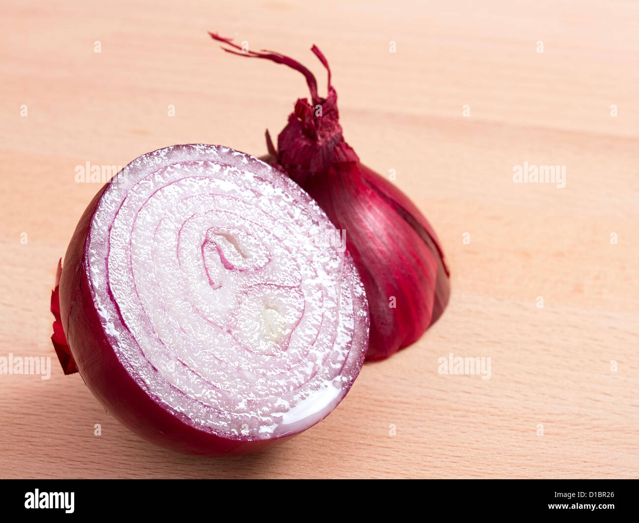 Red onion cut in half on wooden chopping block Stock Photo - Alamy