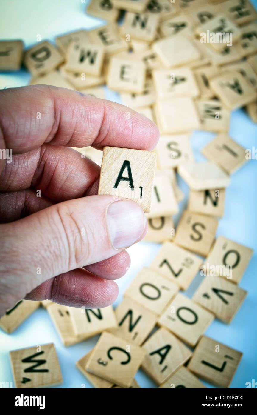 holding a Scrabble tile with letter A Stock Photo - Alamy