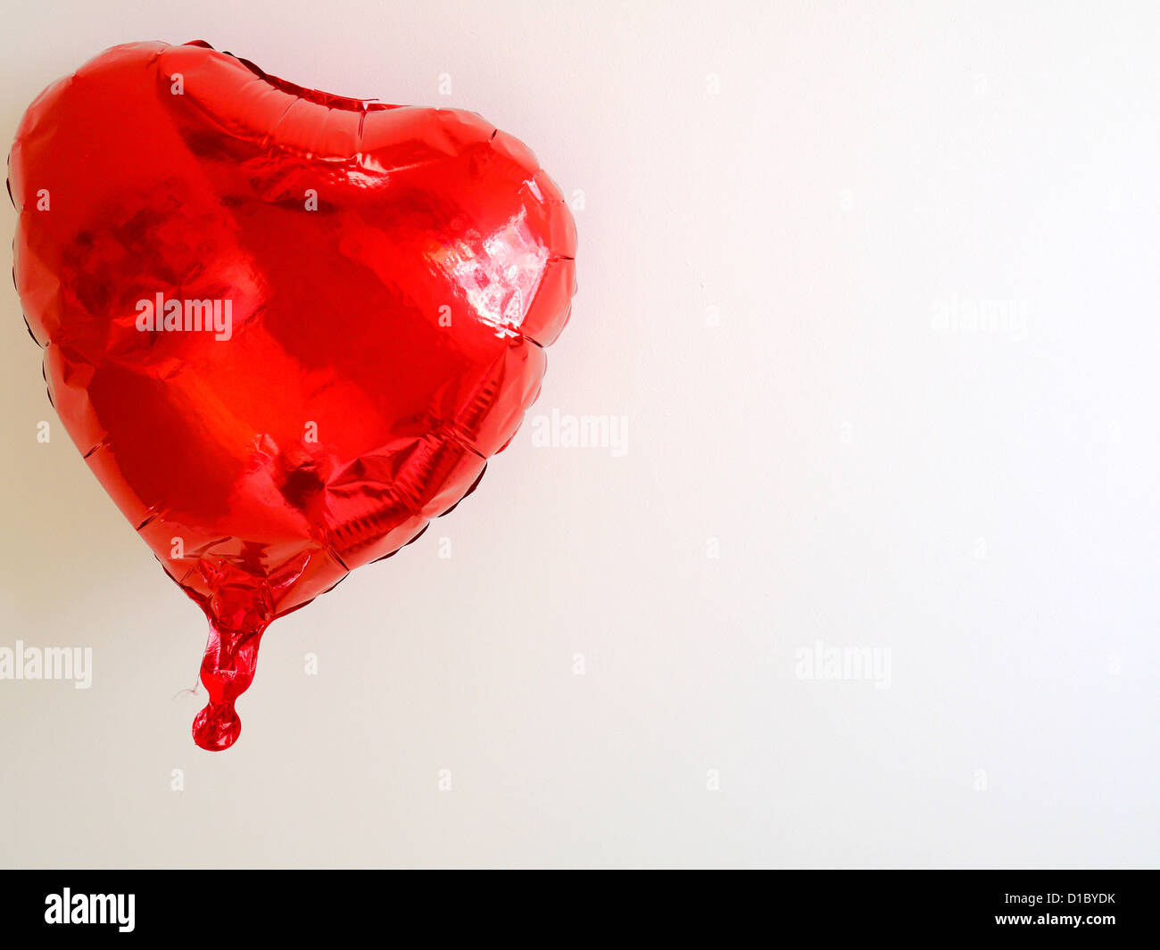 A floating red Helium balloon on a white background Stock Photo - Alamy
