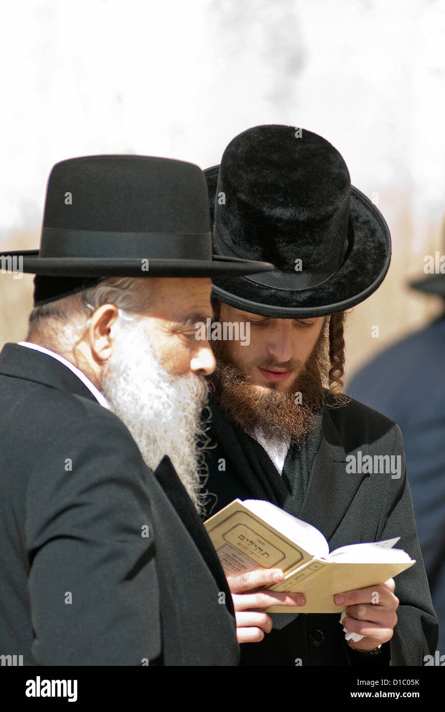 Israel, Jerusalem. A family elder leads a young man in prayer at the ...