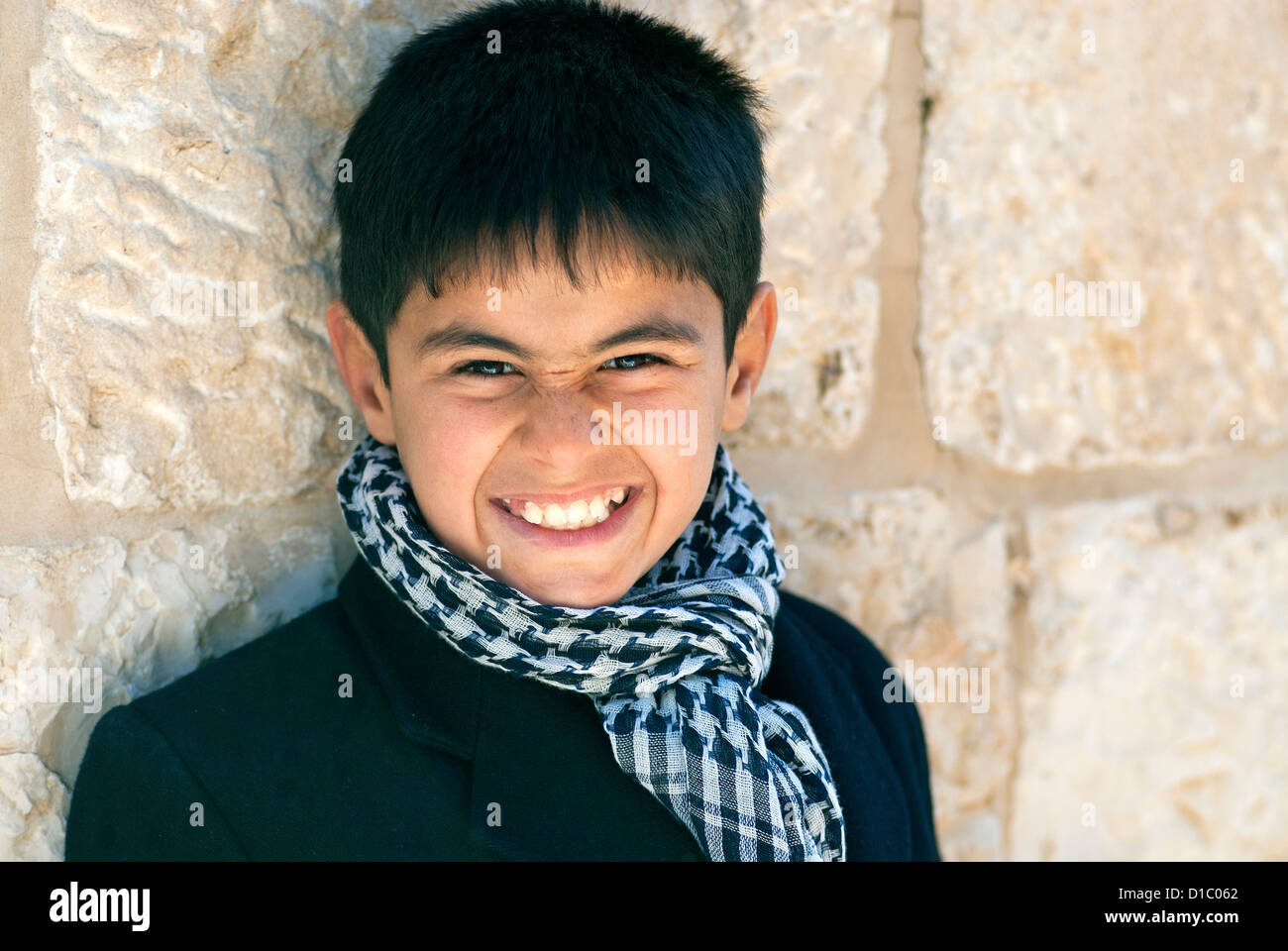 Israel, Jerusalem. A young boy in Jerusalem wears a keffiyeh wrapped ...