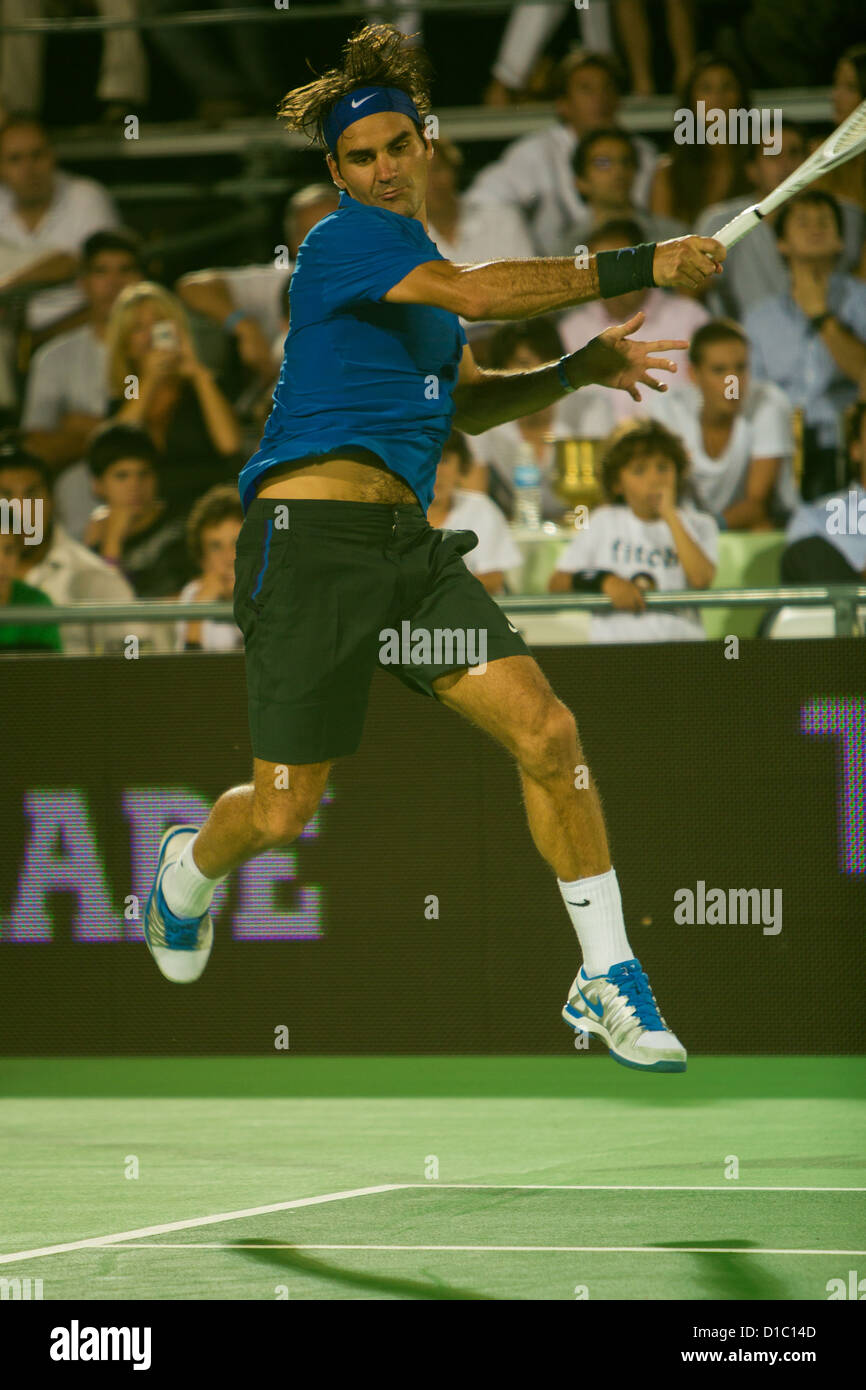 Roger Federer jumping to hit a drive during an exhibition match vs Juan ...