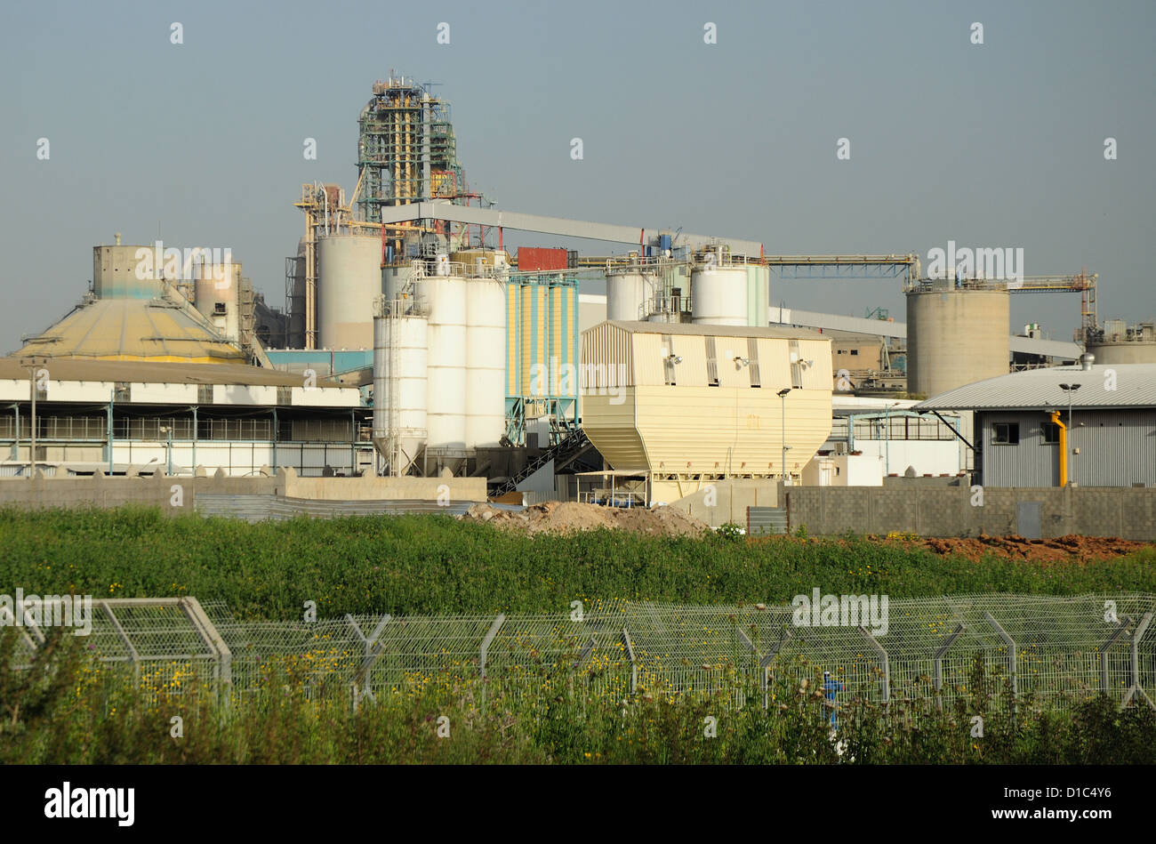 Big industrial facility with the protection fence at the foreground ...