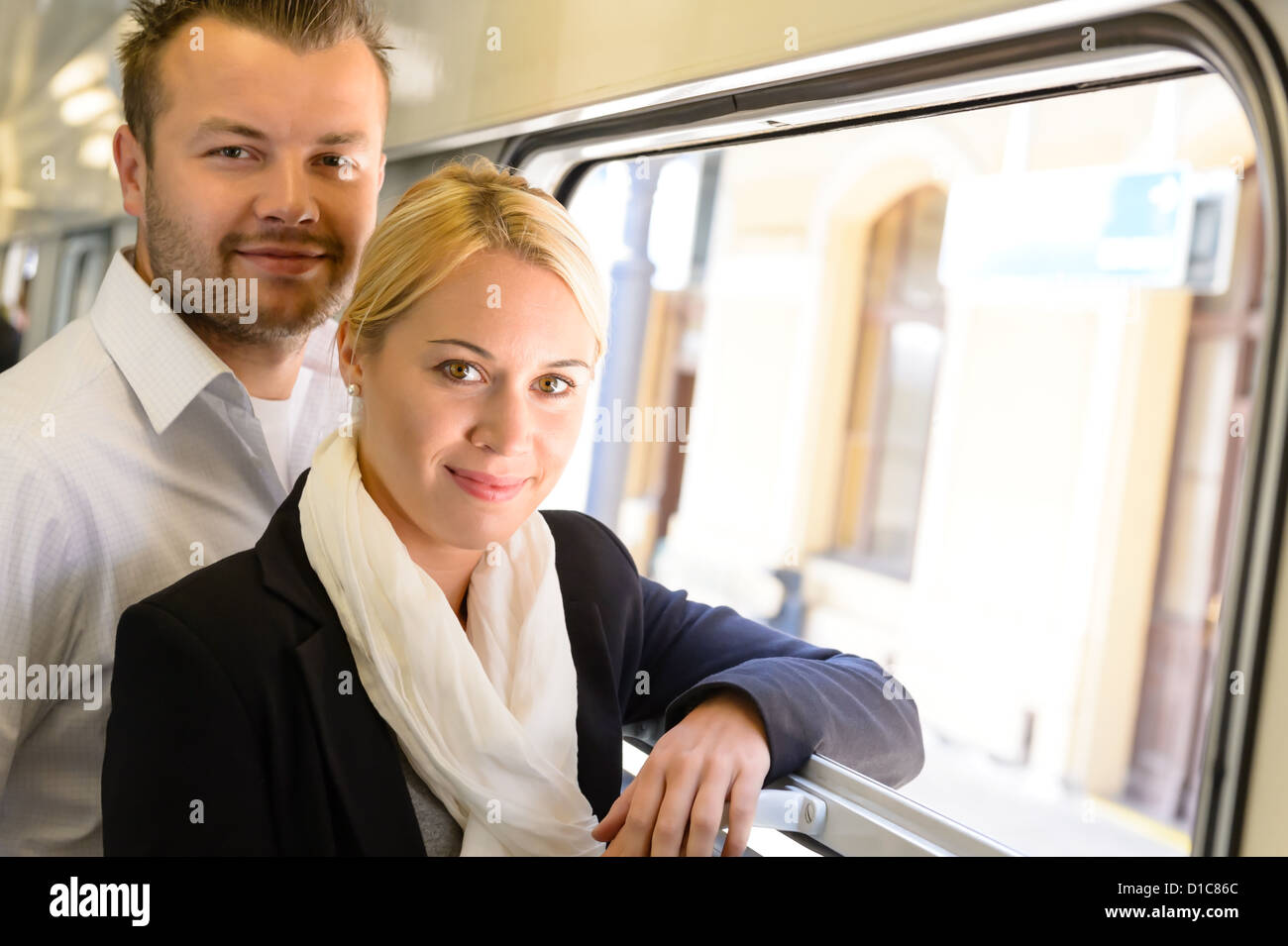 Woman and man standing by train window smiling commuters travel Stock ...