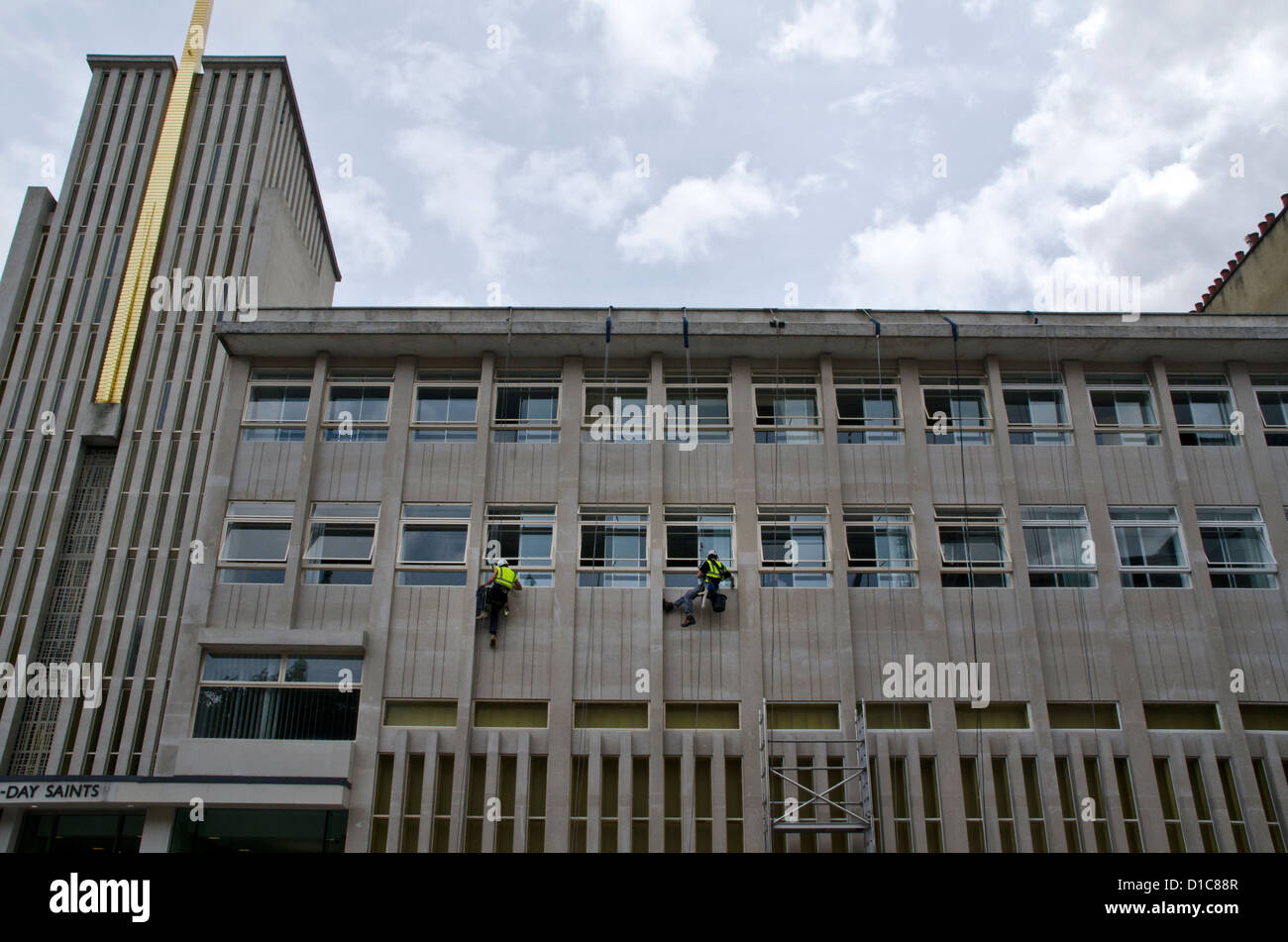 TWO WORKERS HANGING ON THE WALL OF NEWLY CONSTRUCTED BUILDING ...