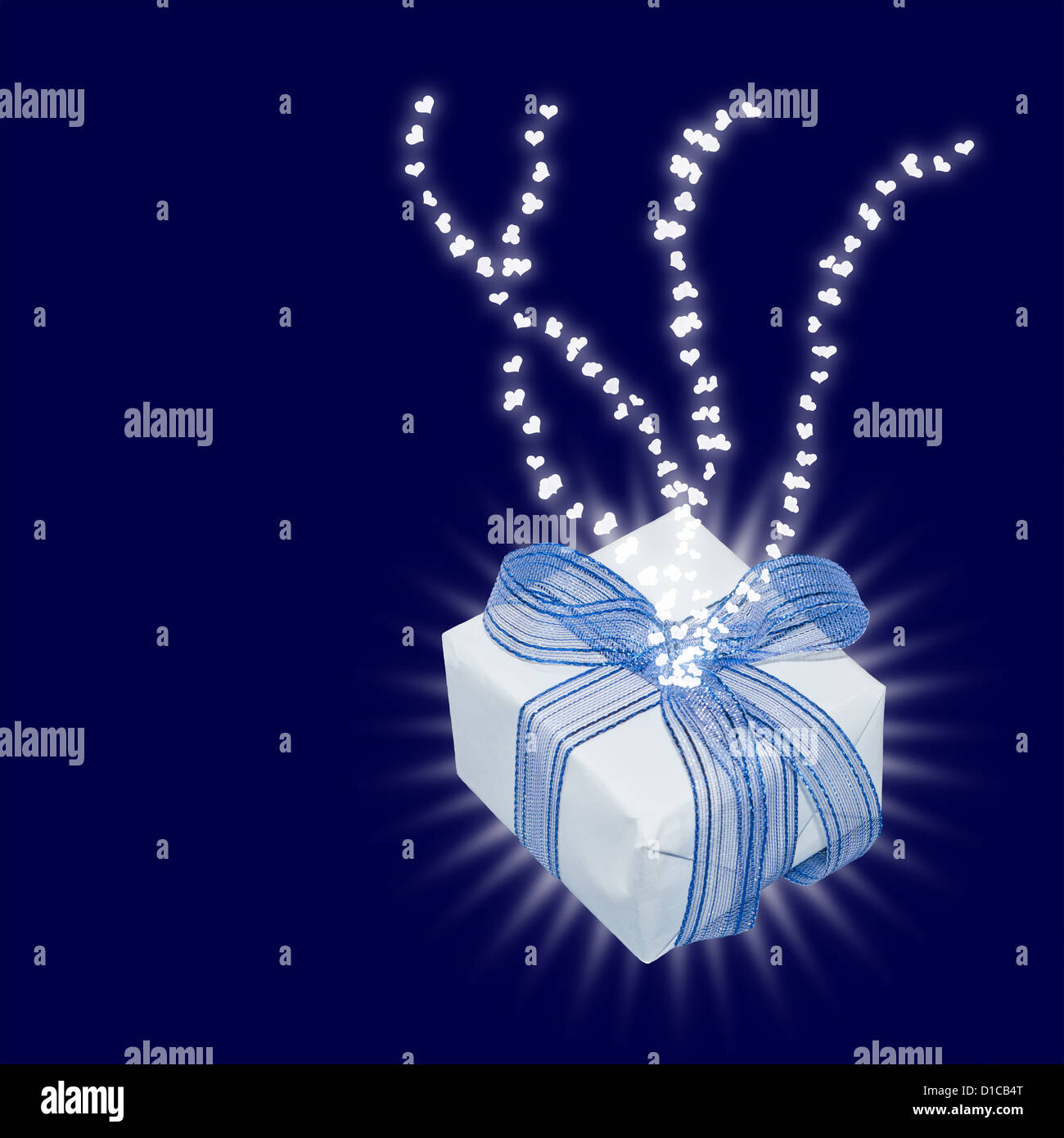 Magic gift with light rays and heart trails; on dark blue background ...