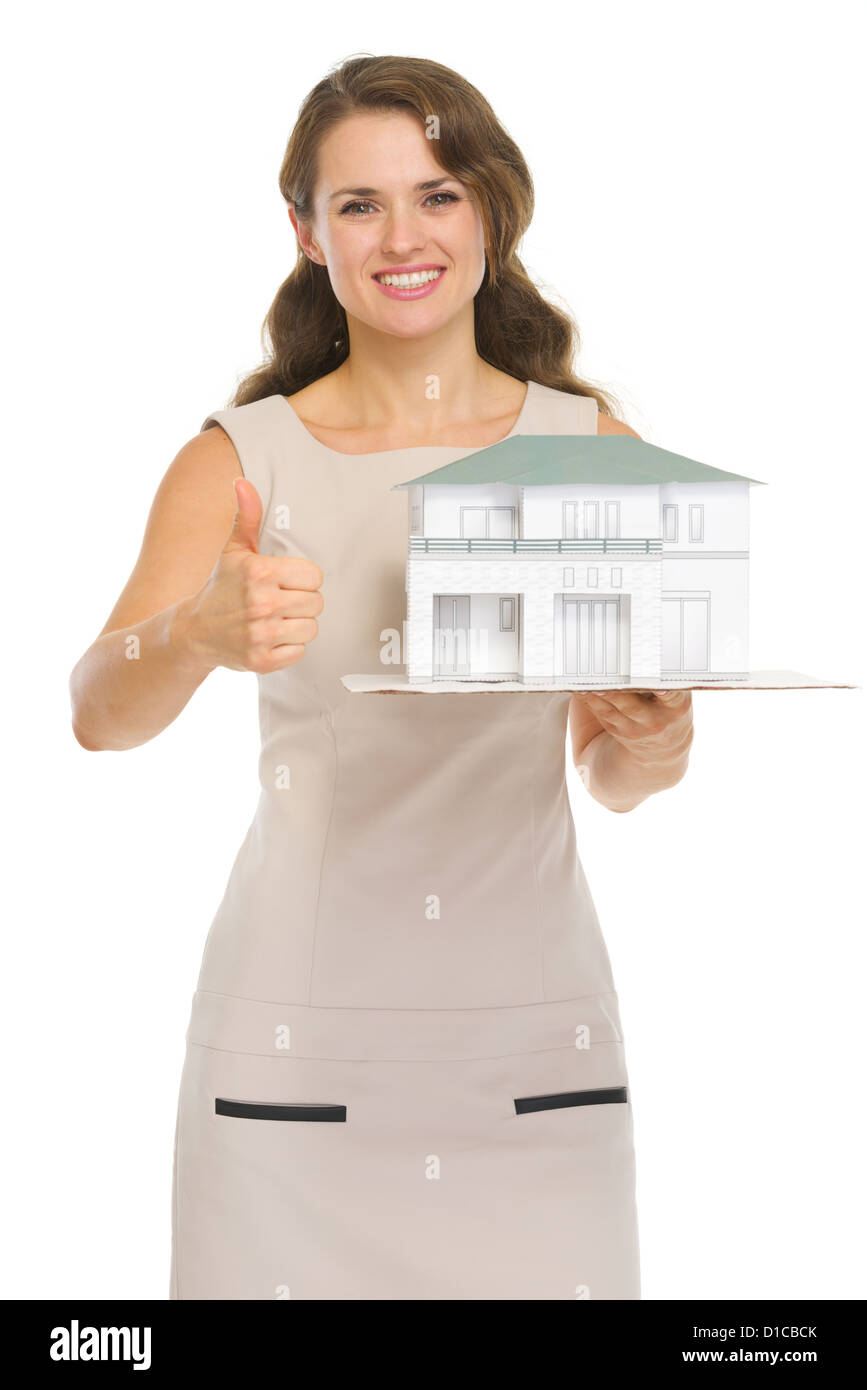 Happy woman landlord with scale model of house showing thumbs up Stock ...