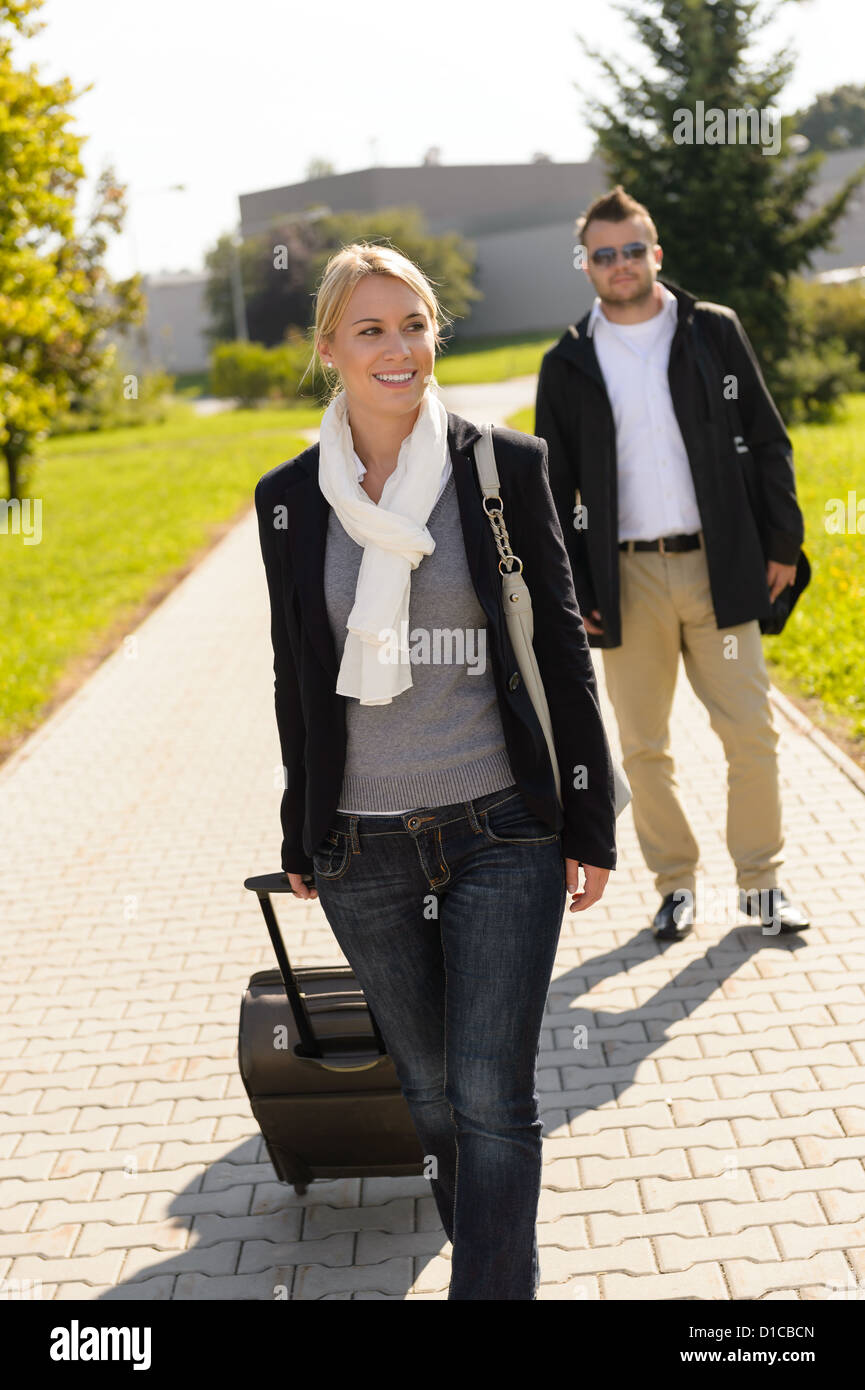 Woman leaving with baggage man walk behind friends commuter travel ...