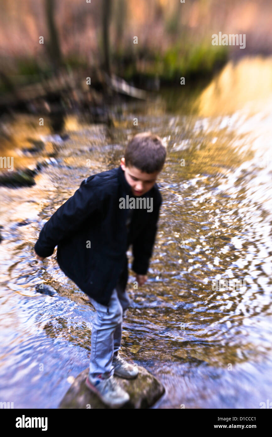 Little boy standing on rock in a stream Stock Photo - Alamy
