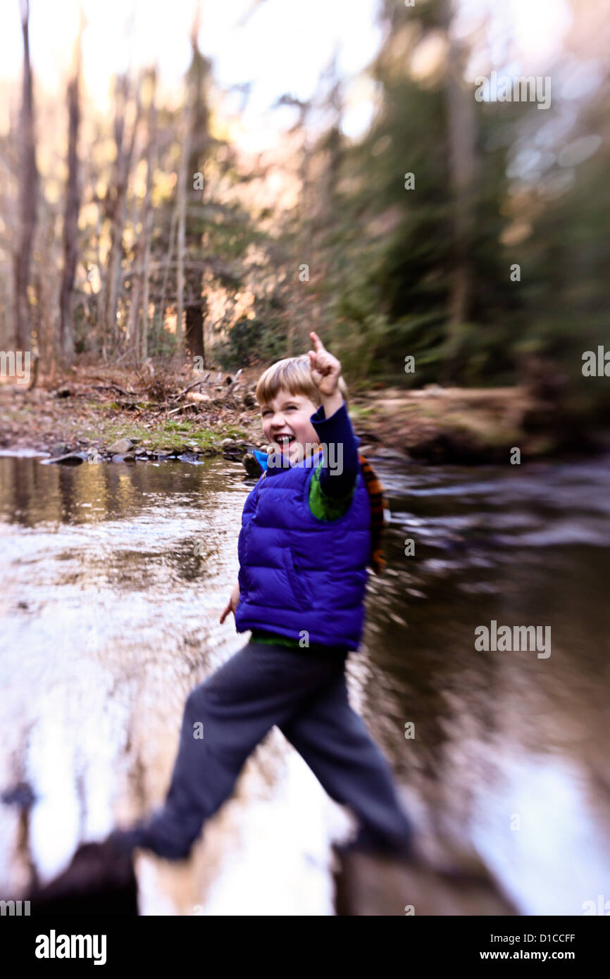 Little boy balancing himself between two rocks in a stream Stock Photo ...
