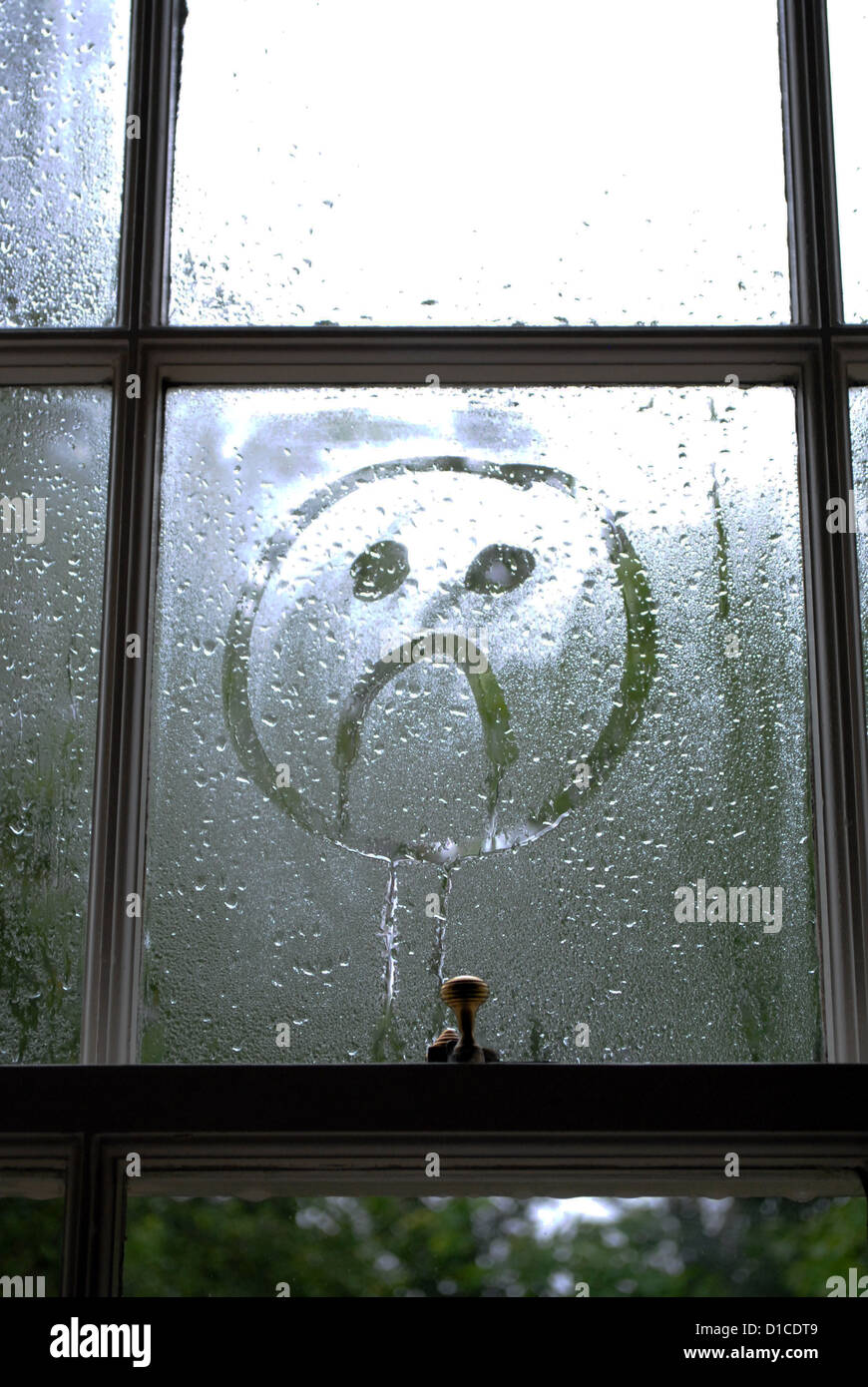 Sad face drawn in window condensation Stock Photo - Alamy