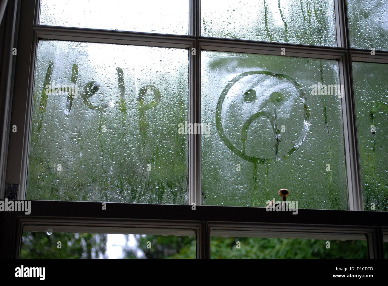 Sad face drawn in window condensation Stock Photo - Alamy